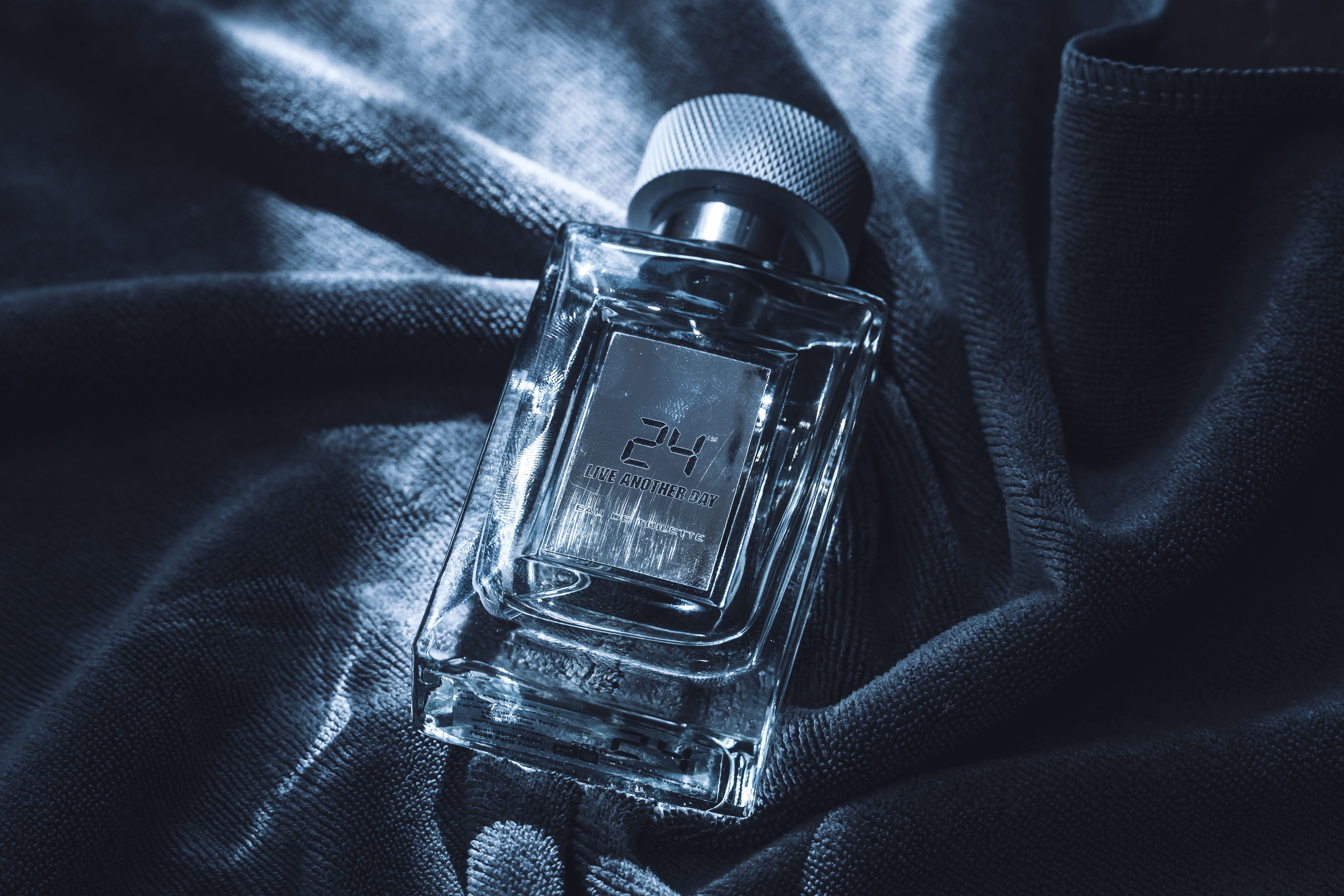 Elegant Perfume Bottle on Textured Fabric · Free Stock Photo