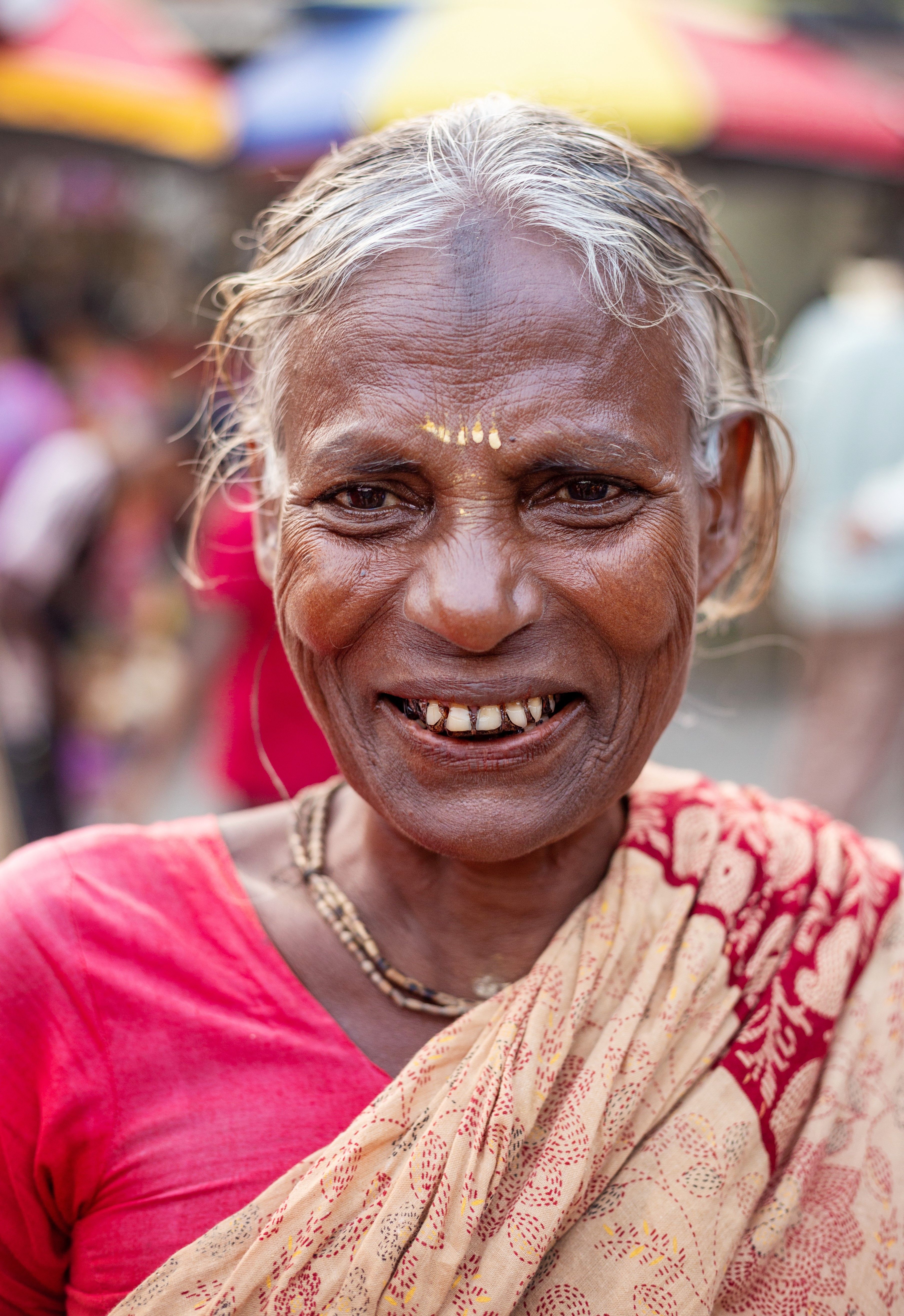 Smiling Elderly Woman in Vibrant Market Scene · Free Stock Photo