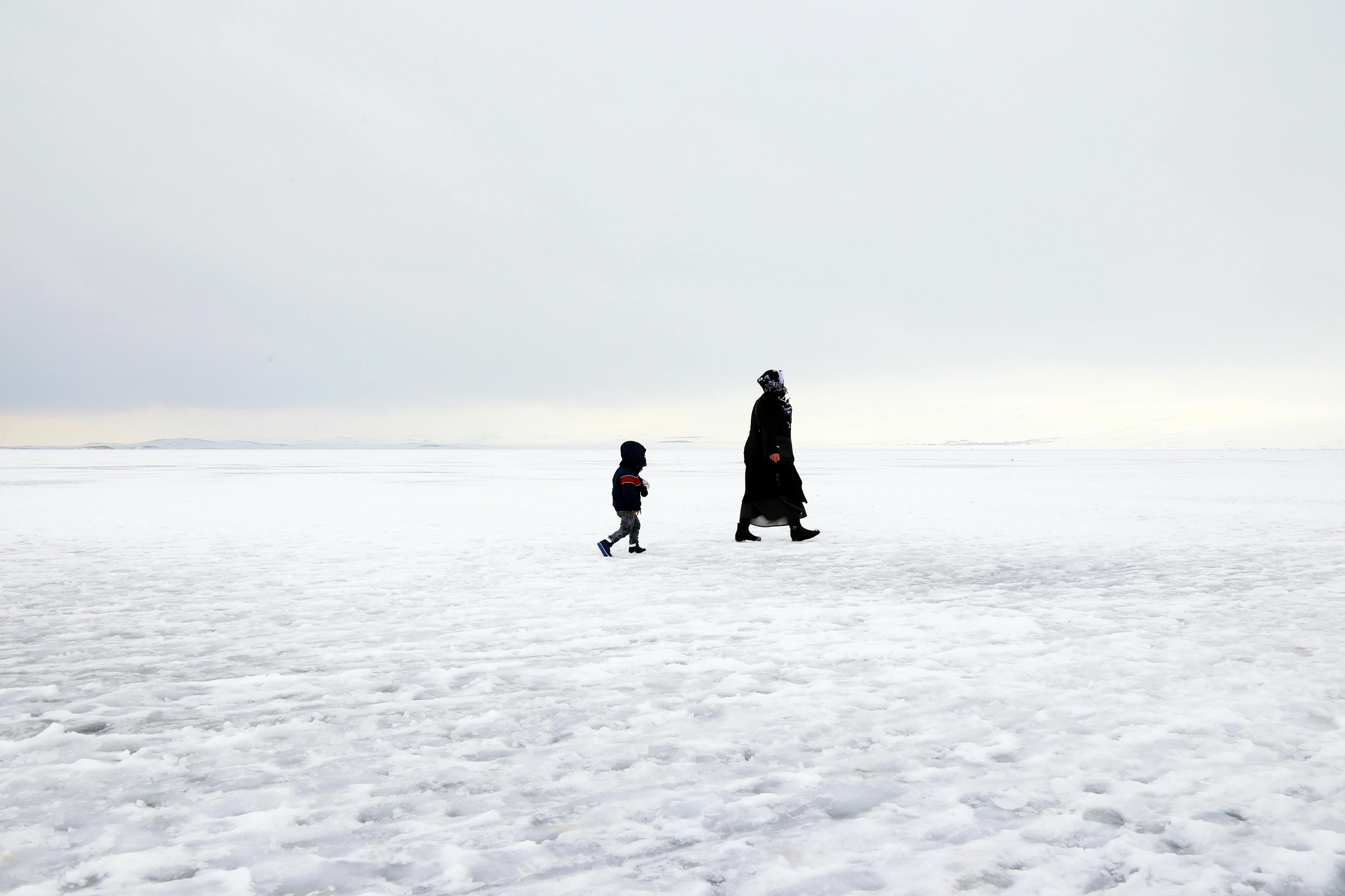Two People Walking on Snow Covered Ground · Free Stock Photo