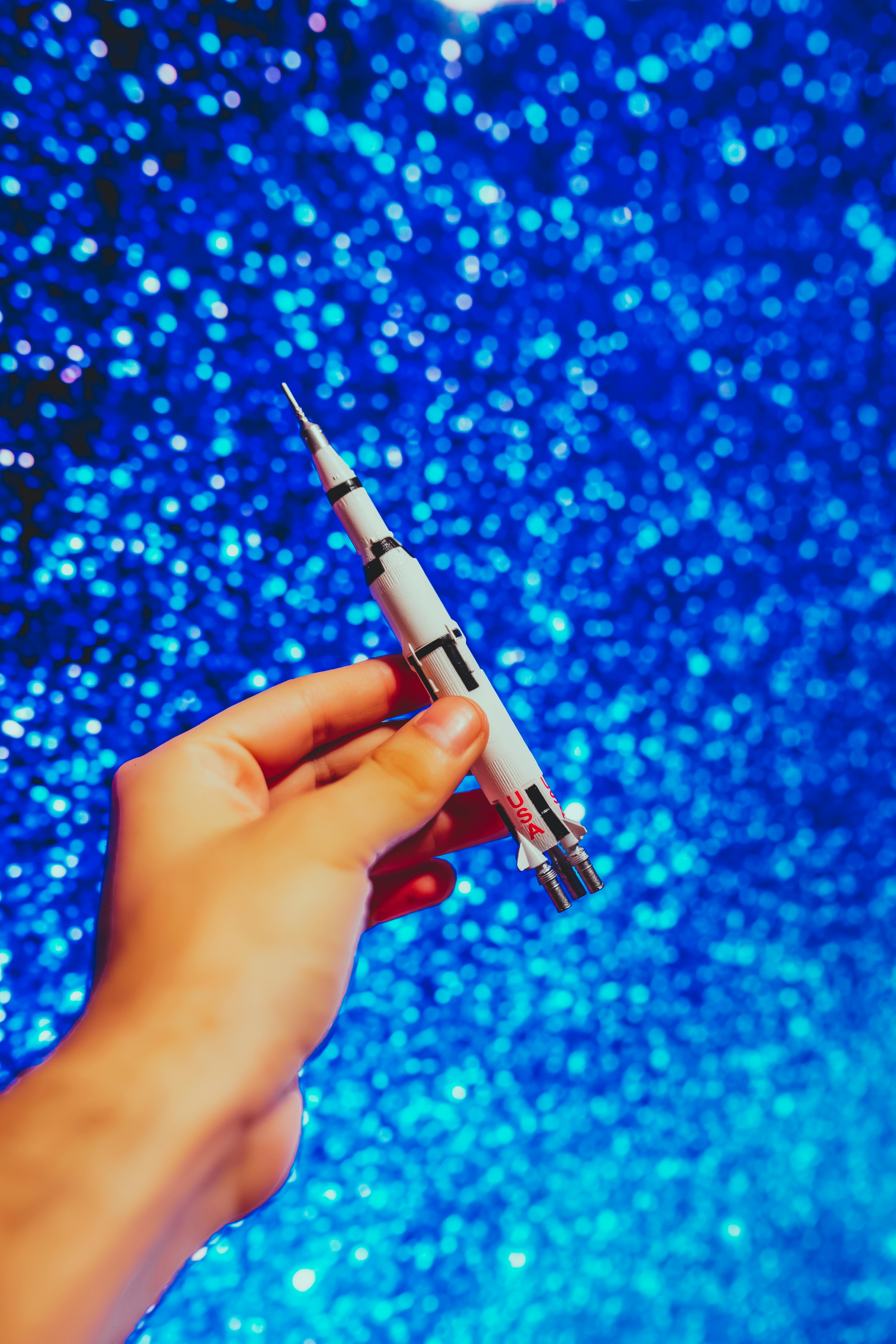 Person Holding A Miniature Rocketship Click Pen · Free Stock Photo