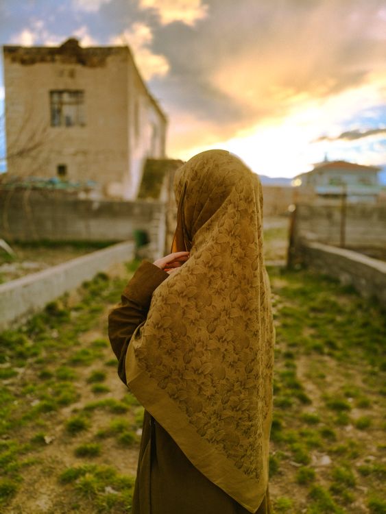 Woman in Hijab Gazing at Sunset in Rural Setting · Free Stock Photo