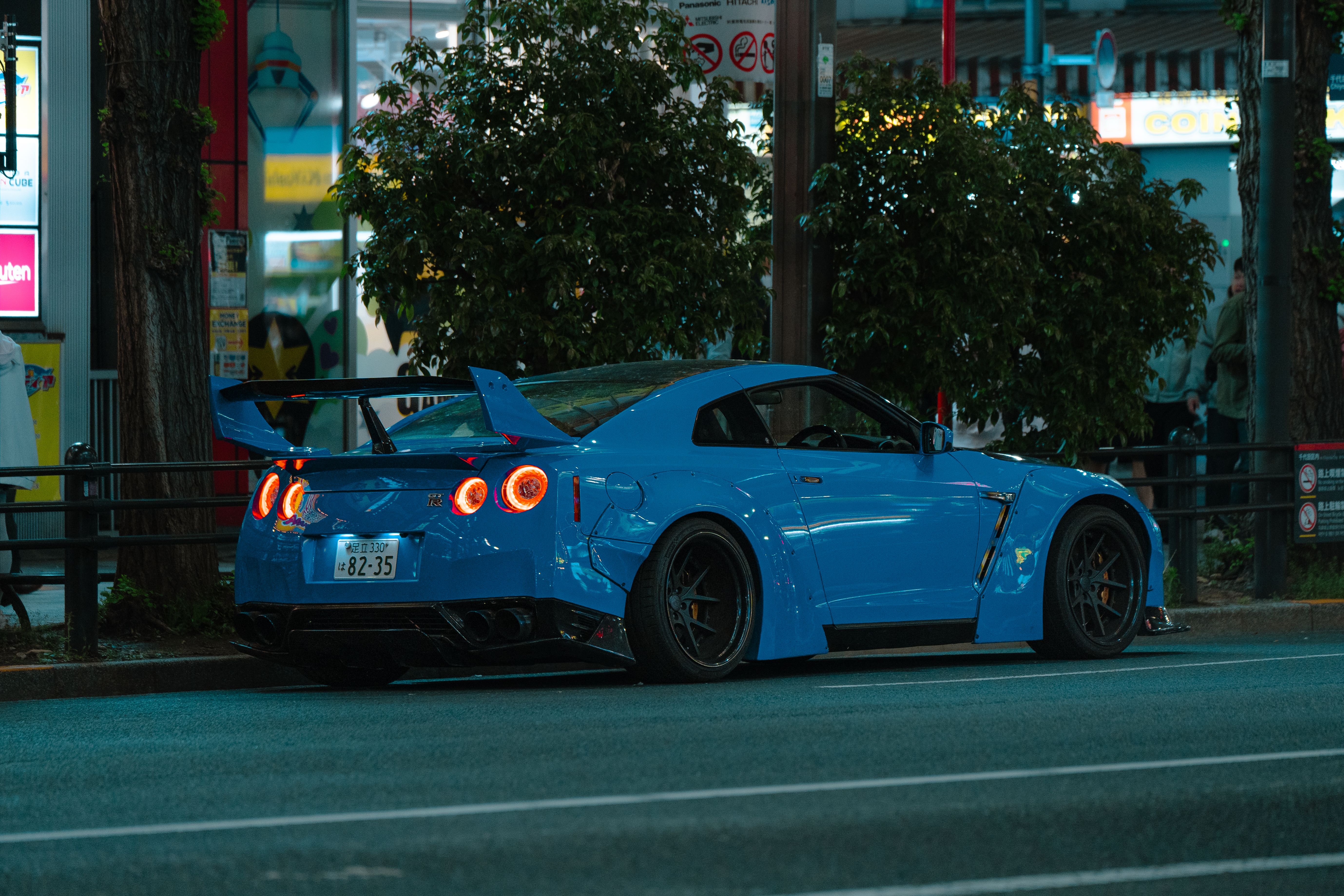 Vibrant Blue Car Parked on Tokyo Street at Night · Free Stock Photo
