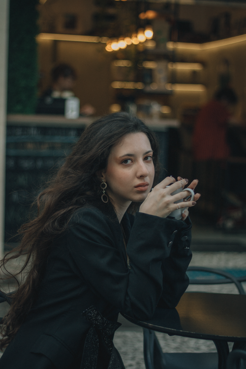 Young Woman in Café with Coffee Mug · Free Stock Photo