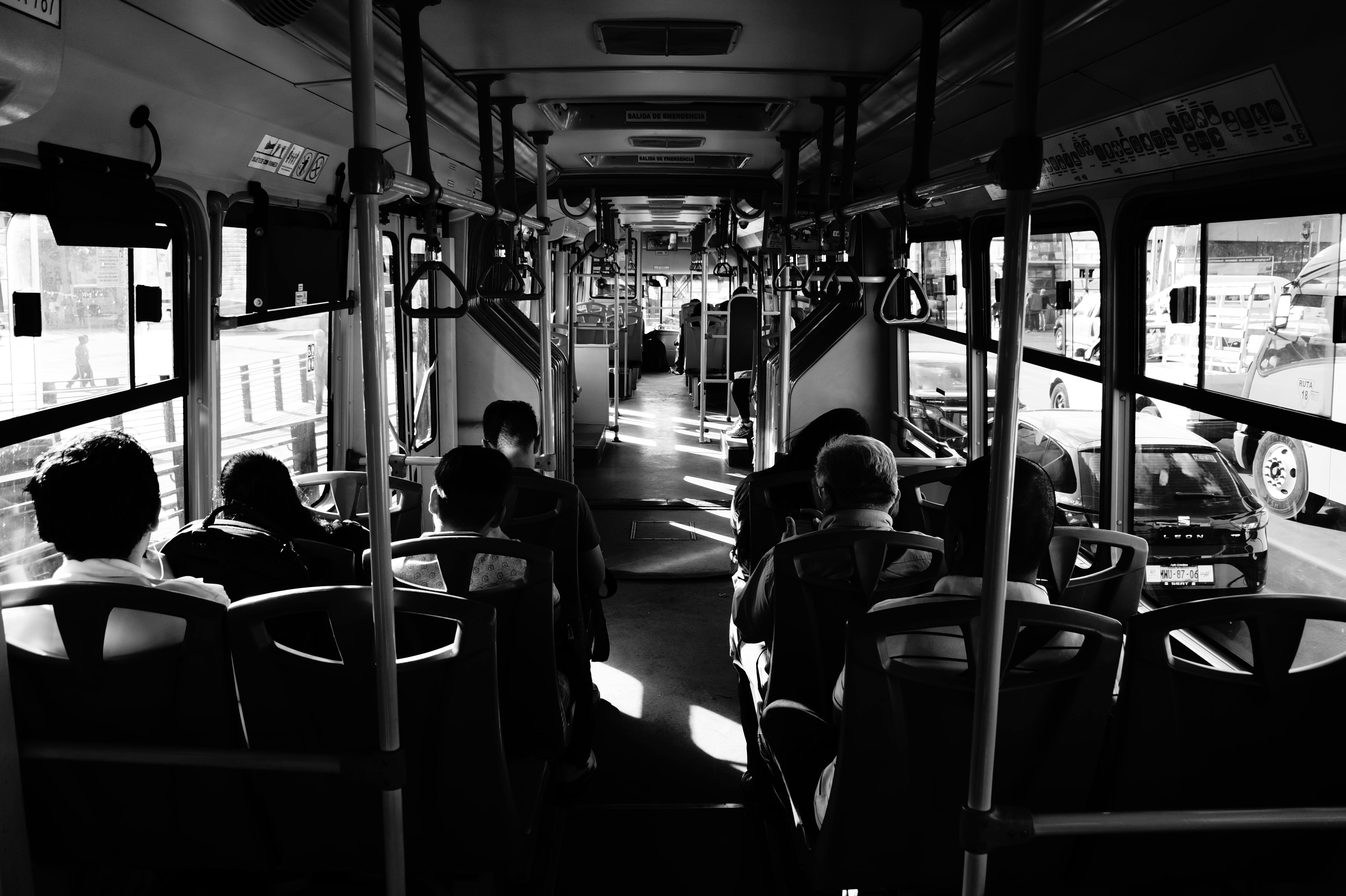 Grayscale Photo Of People Sitting Inside A Bus · Free Stock Photo