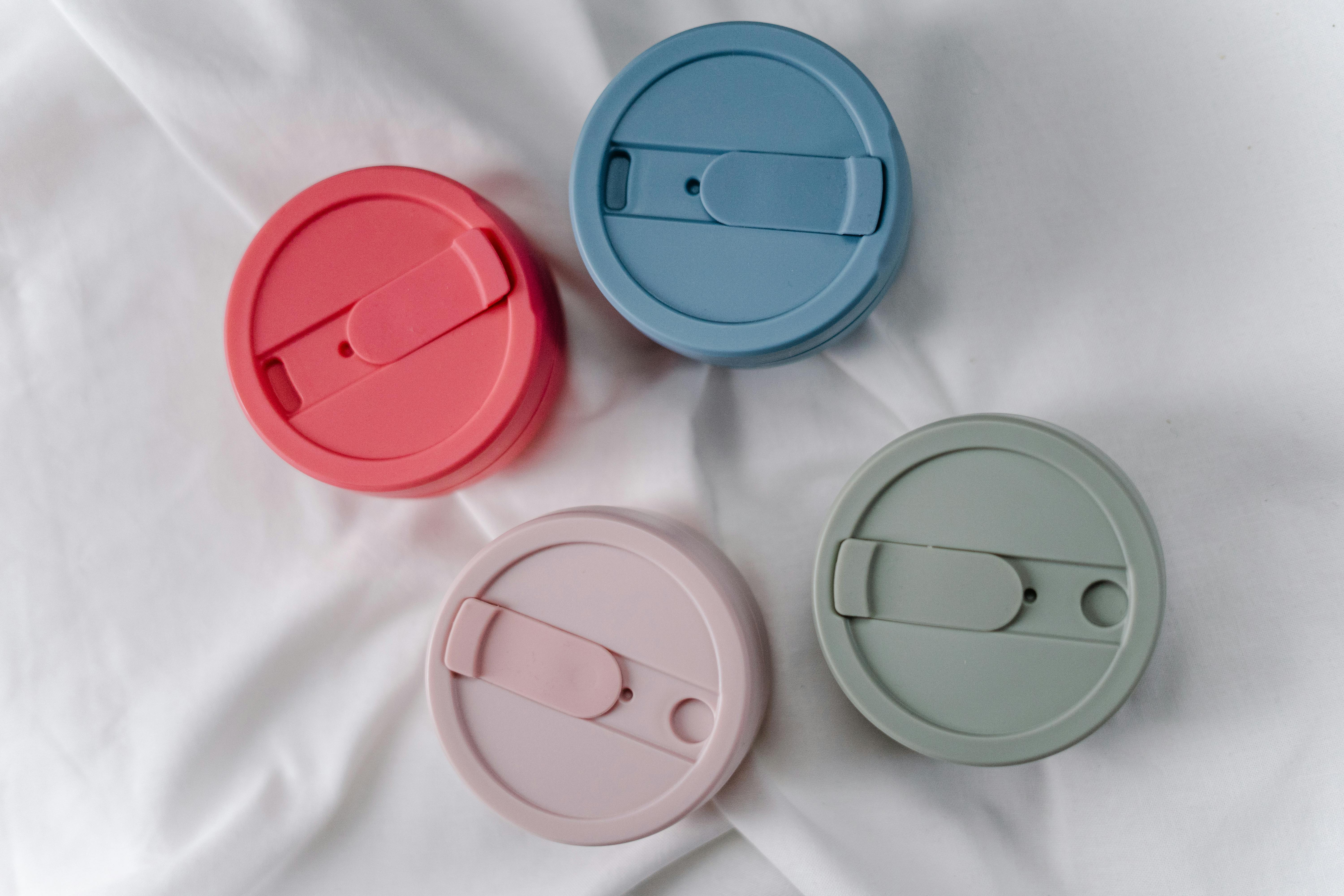 Colorful Silicone Cup Lids on White Surface · Free Stock Photo