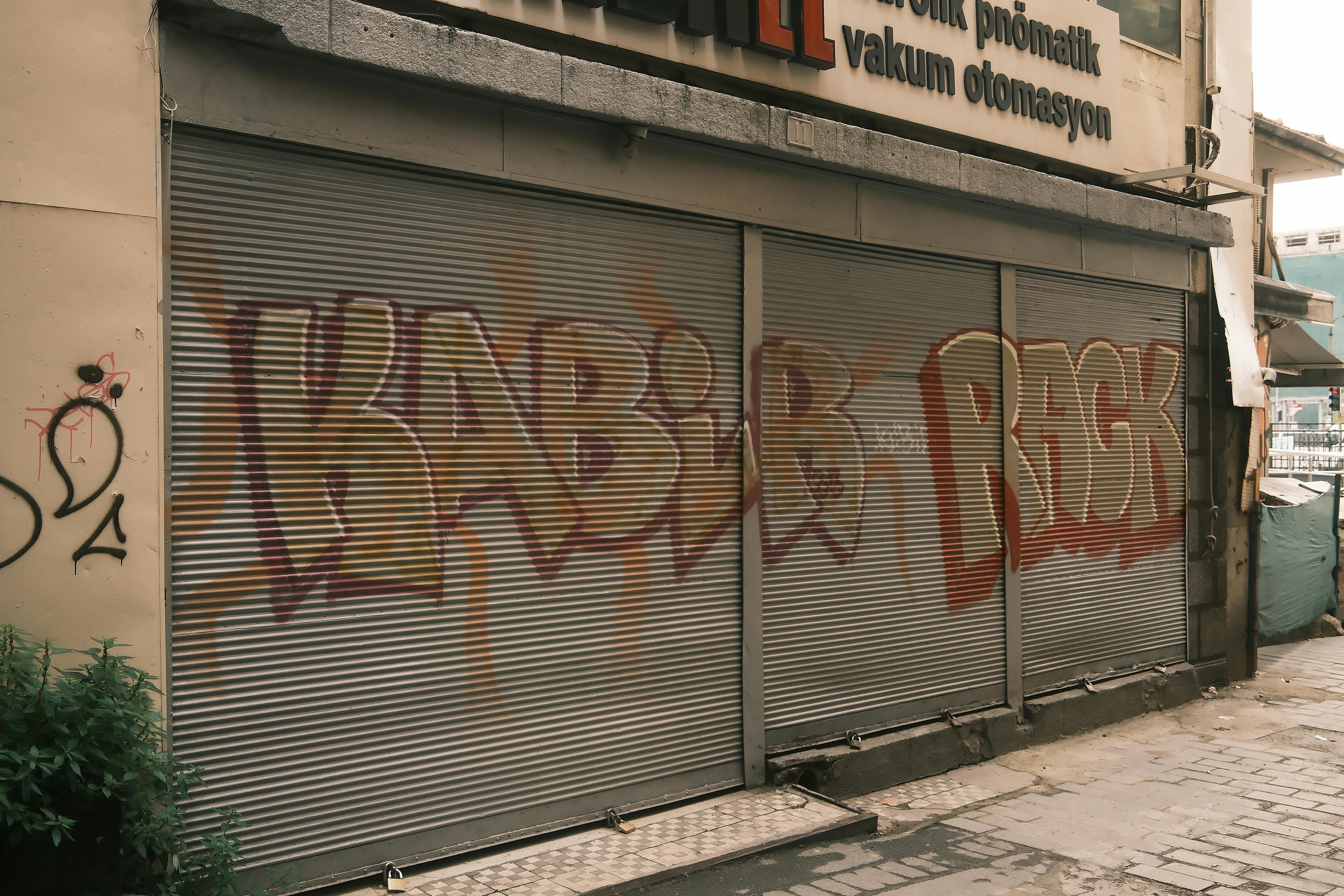 Urban Street with Graffiti on Metal Shutter · Free Stock Photo