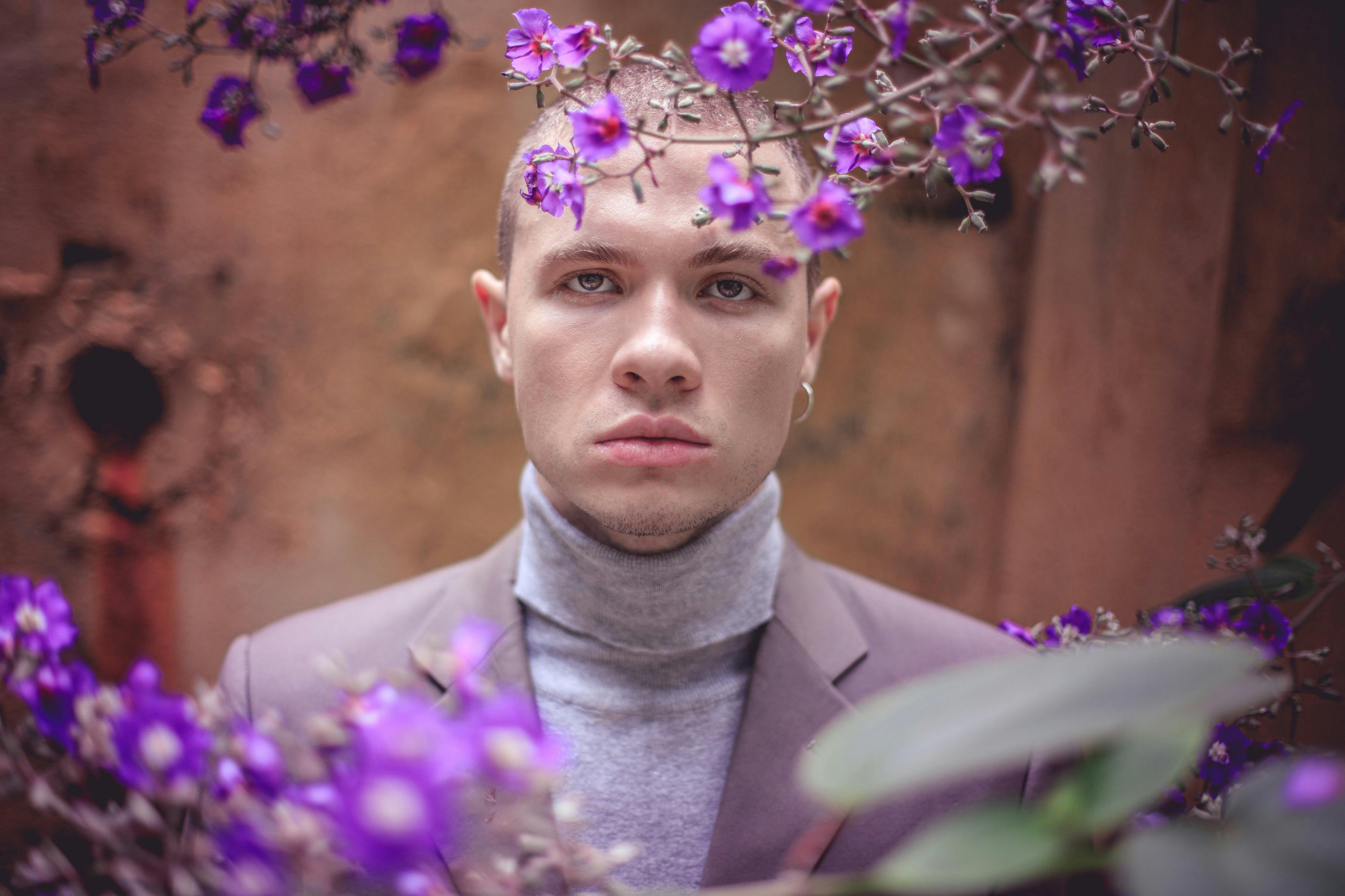 Emotionless man in blooming branches · Free Stock Photo