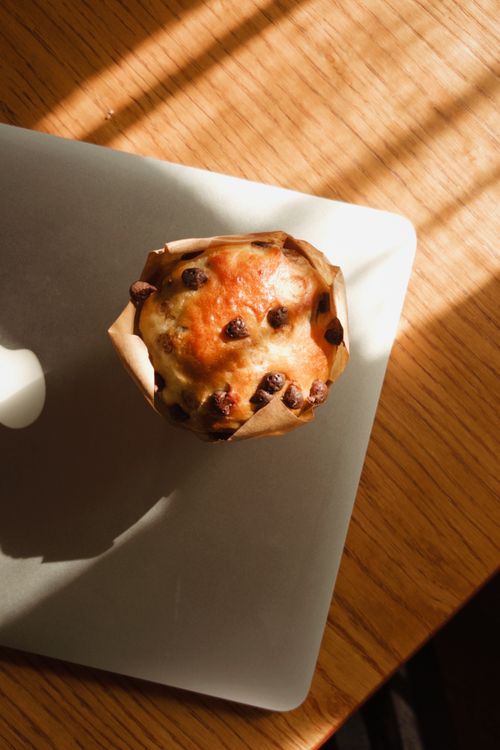 Muffin De Chispas De Chocolate Sobre Una Computadora Portátil Con Luz ...