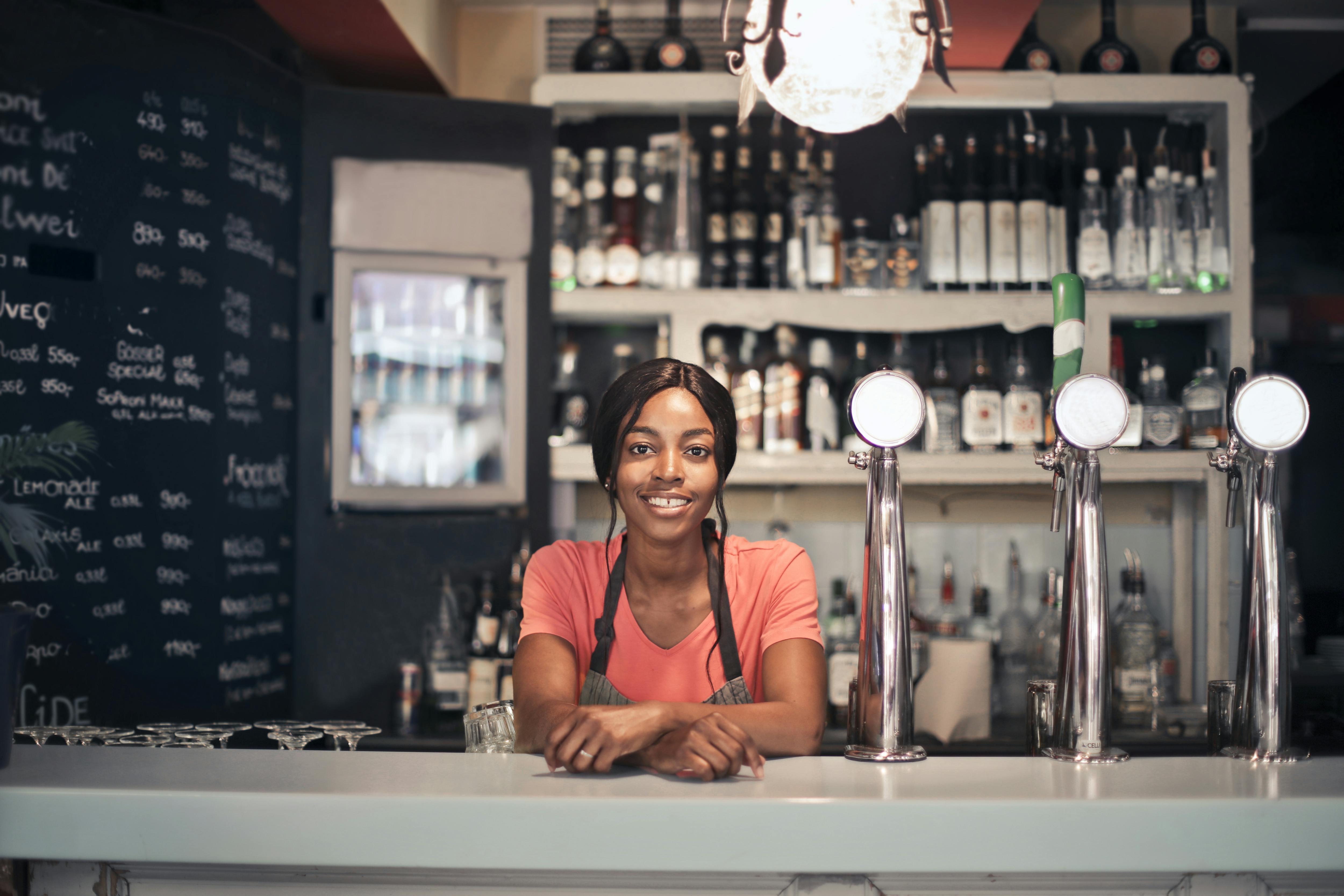 Photo of Smiling Bartender Leaning on Counter · Free Stock Photo