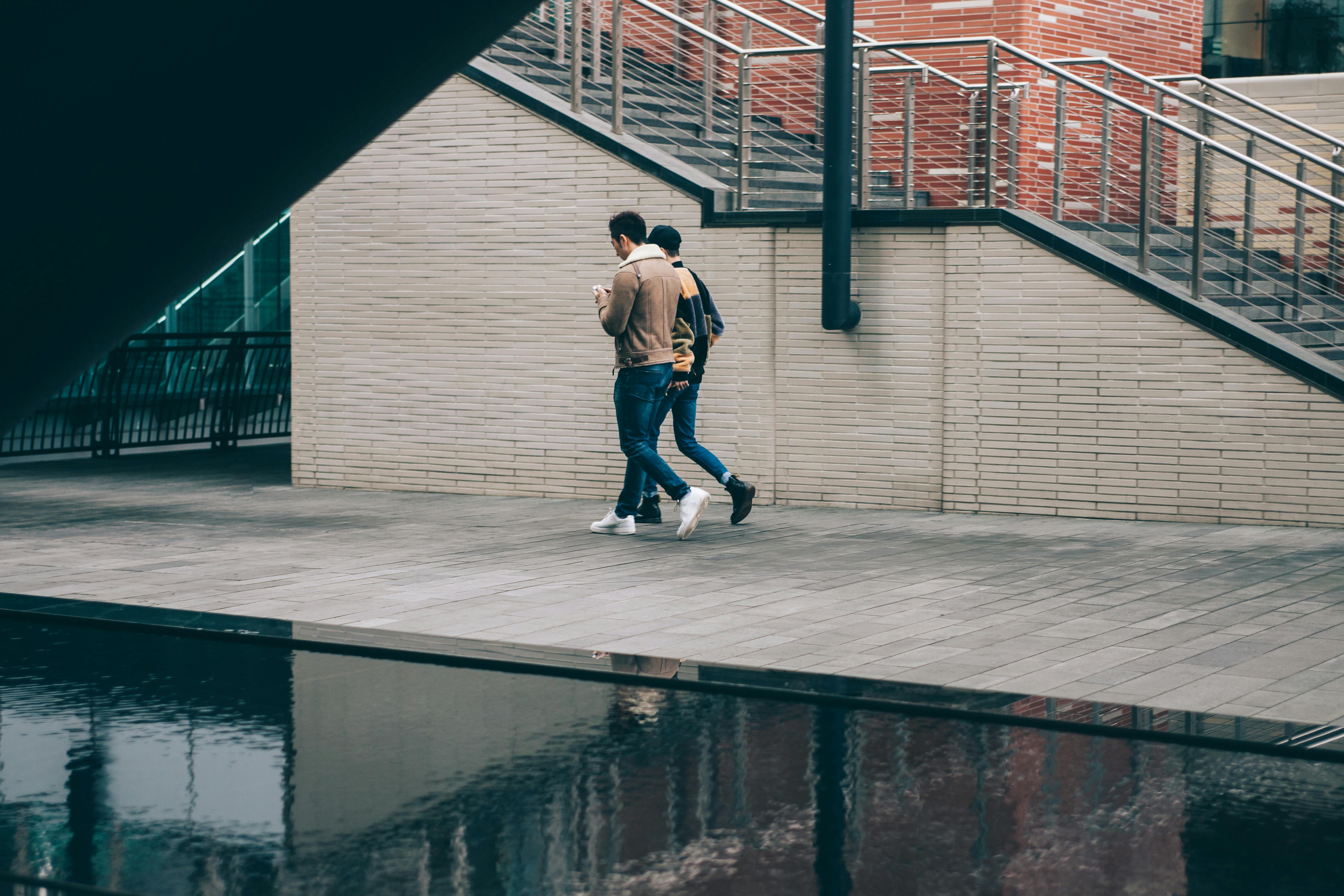 Two Men Walking Beside Staircase · Free Stock Photo
