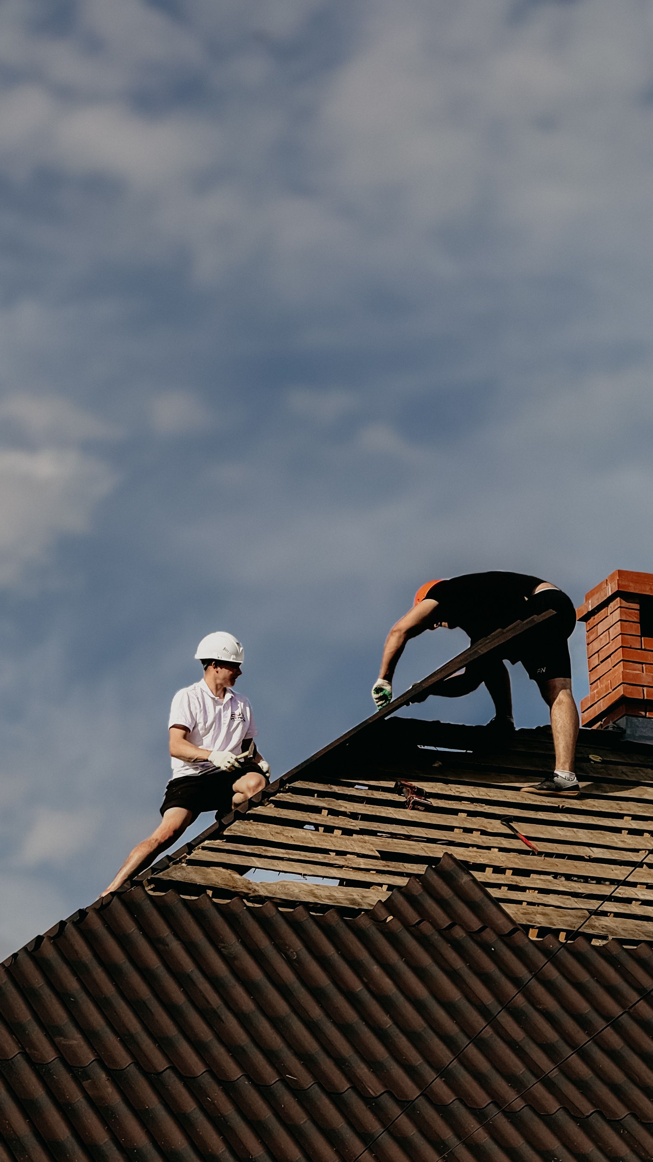 Roofer Working on Roof Installation with Safety Gear · Free Stock Photo