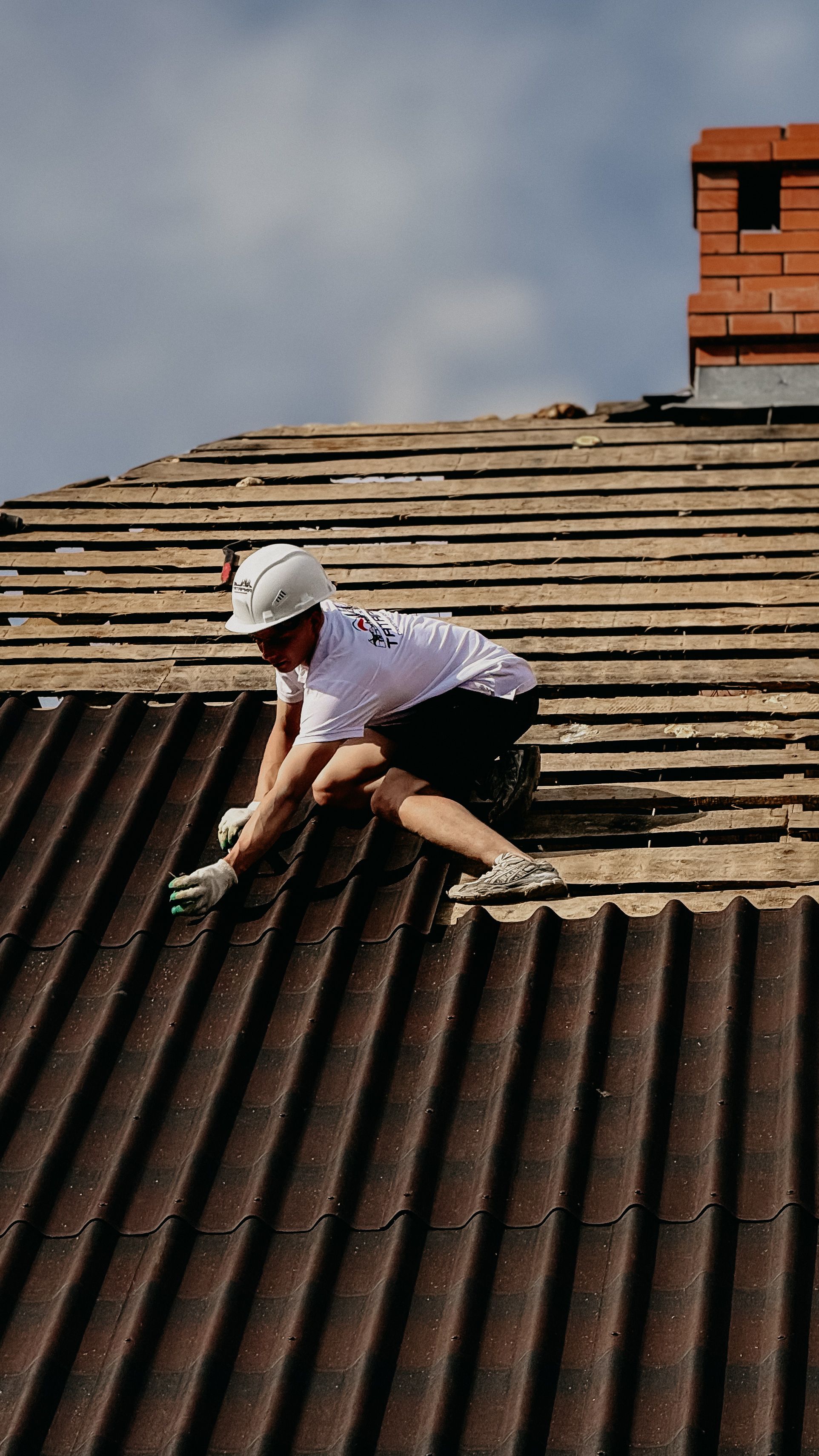 Roofer Working on Roof Installation with Safety Gear · Free Stock Photo