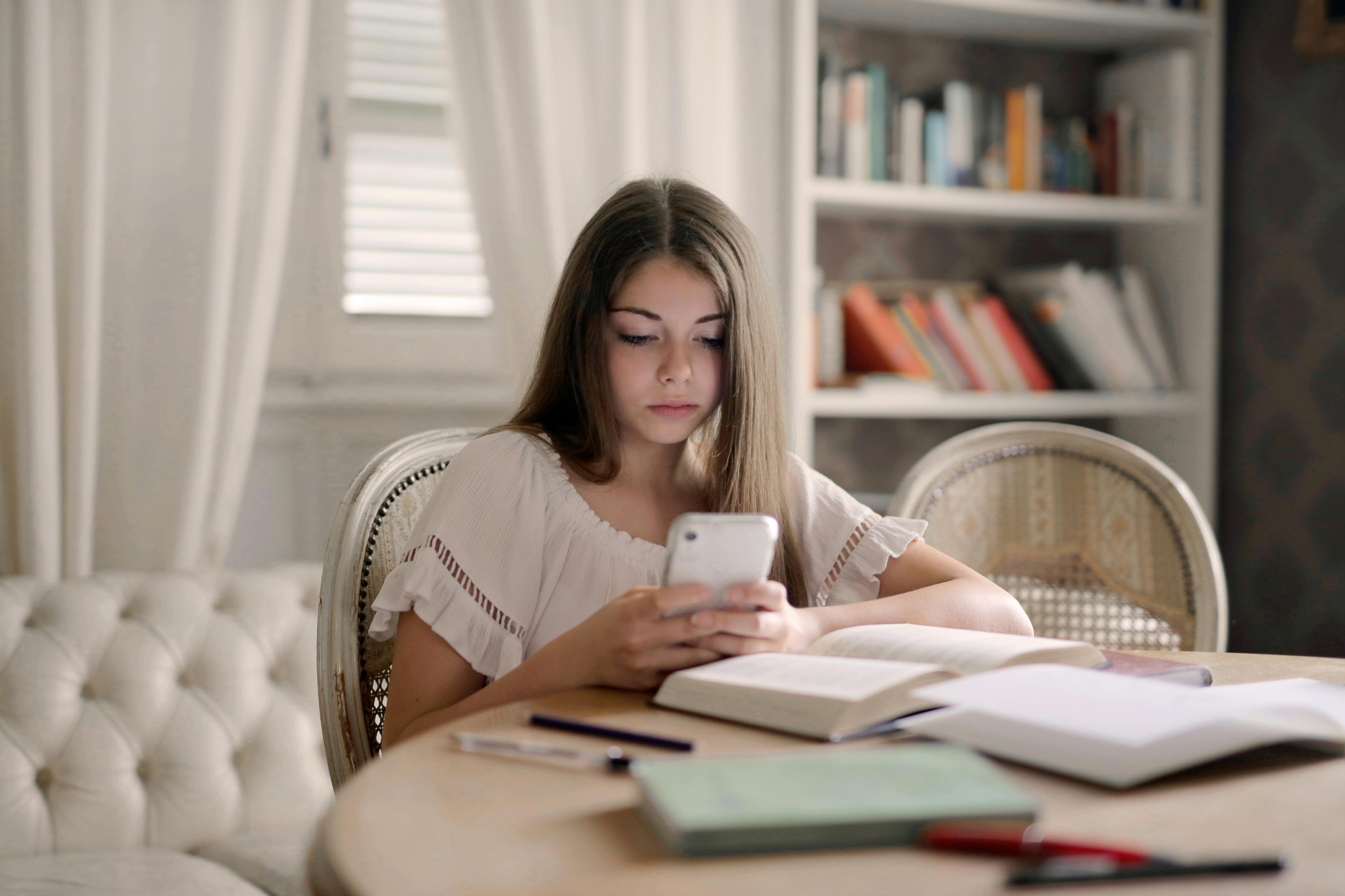 Woman in White Top While Holding White Smartphone · Free Stock Photo