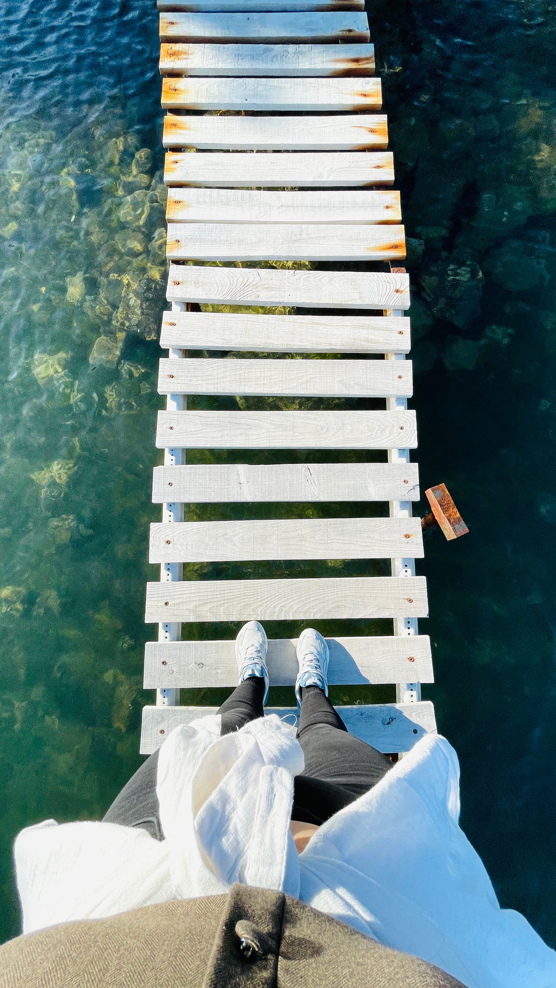 Person Standing on Wooden Dock Over Clear Blue Water · Free Stock Photo