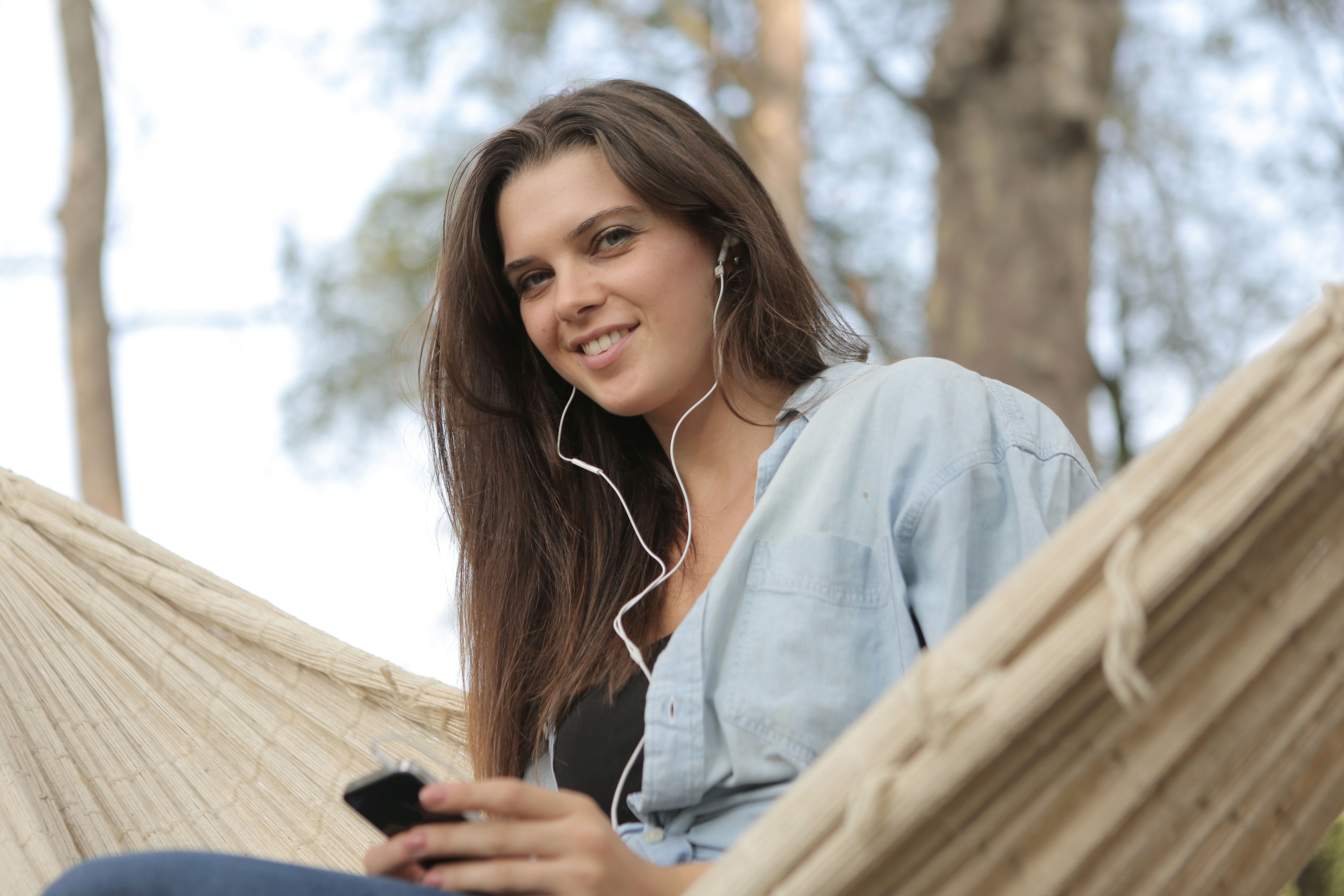 Woman Sitting on Hammock While Listening to Music · Free Stock Photo