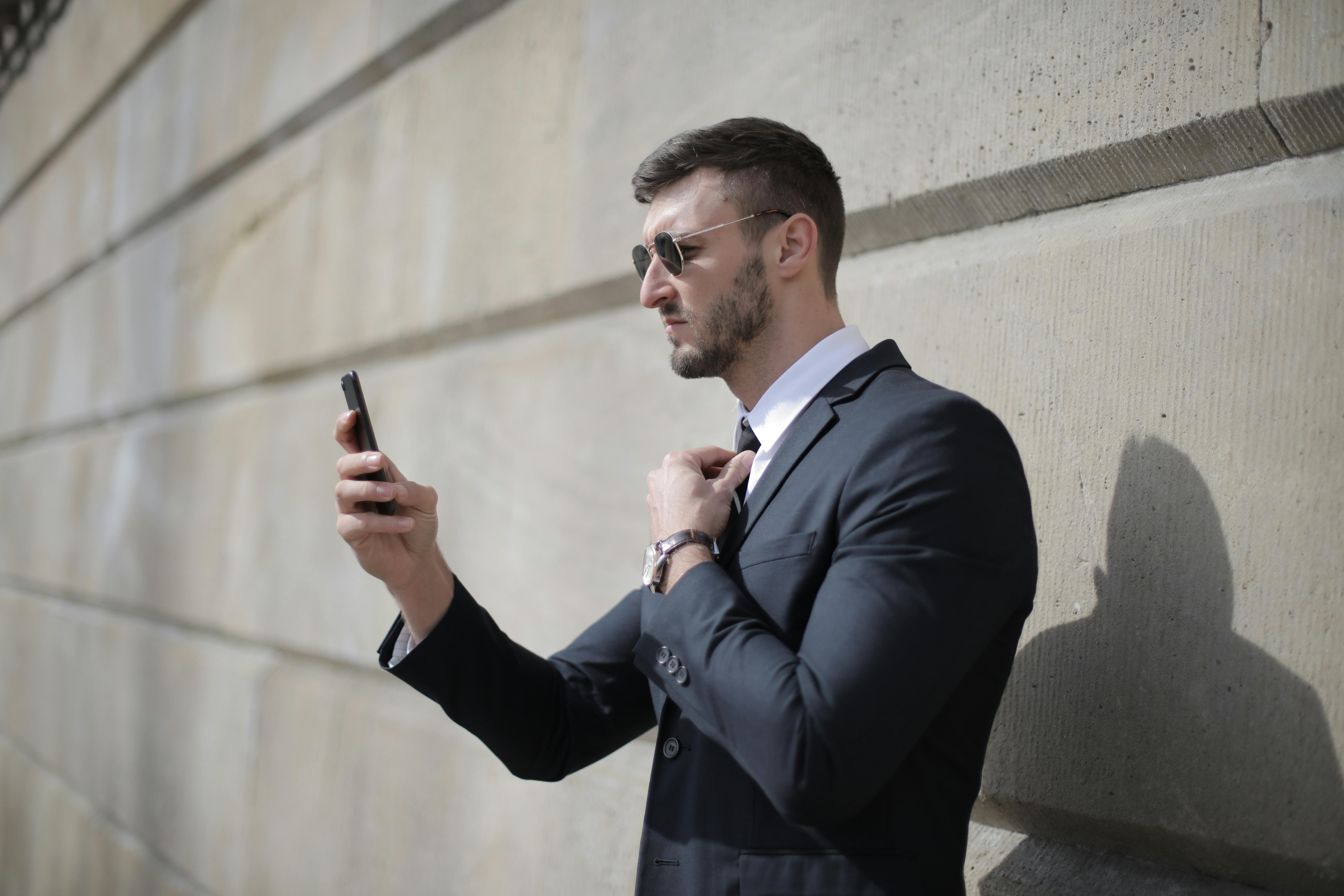 Man in Black Suit Jacket Holding Smartphone · Free Stock Photo