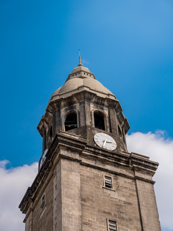 Historic Manila Cathedral Clock Tower Against Blue Sky · Free Stock Photo