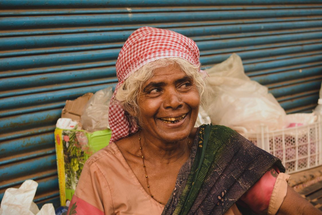 Smiling Elderly Woman in Vibrant Market Scene · Free Stock Photo