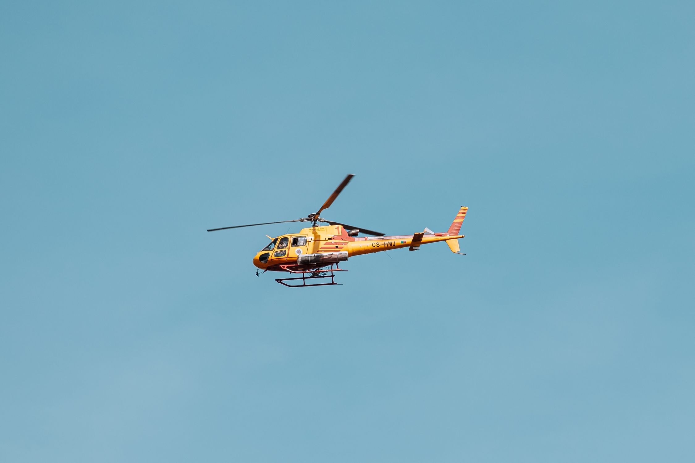 Yellow Helicopter in Flight Against Clear Sky · Free Stock Photo