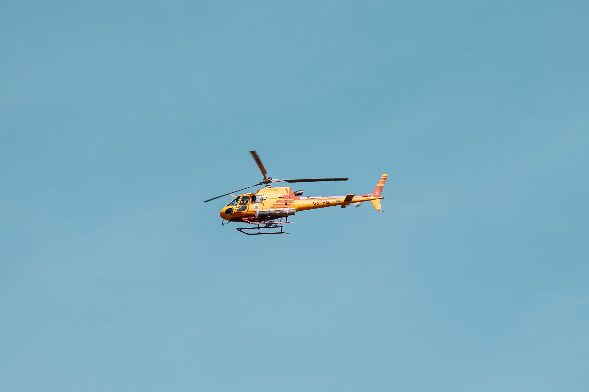 Yellow Helicopter Flying against Clear Sky · Free Stock Photo