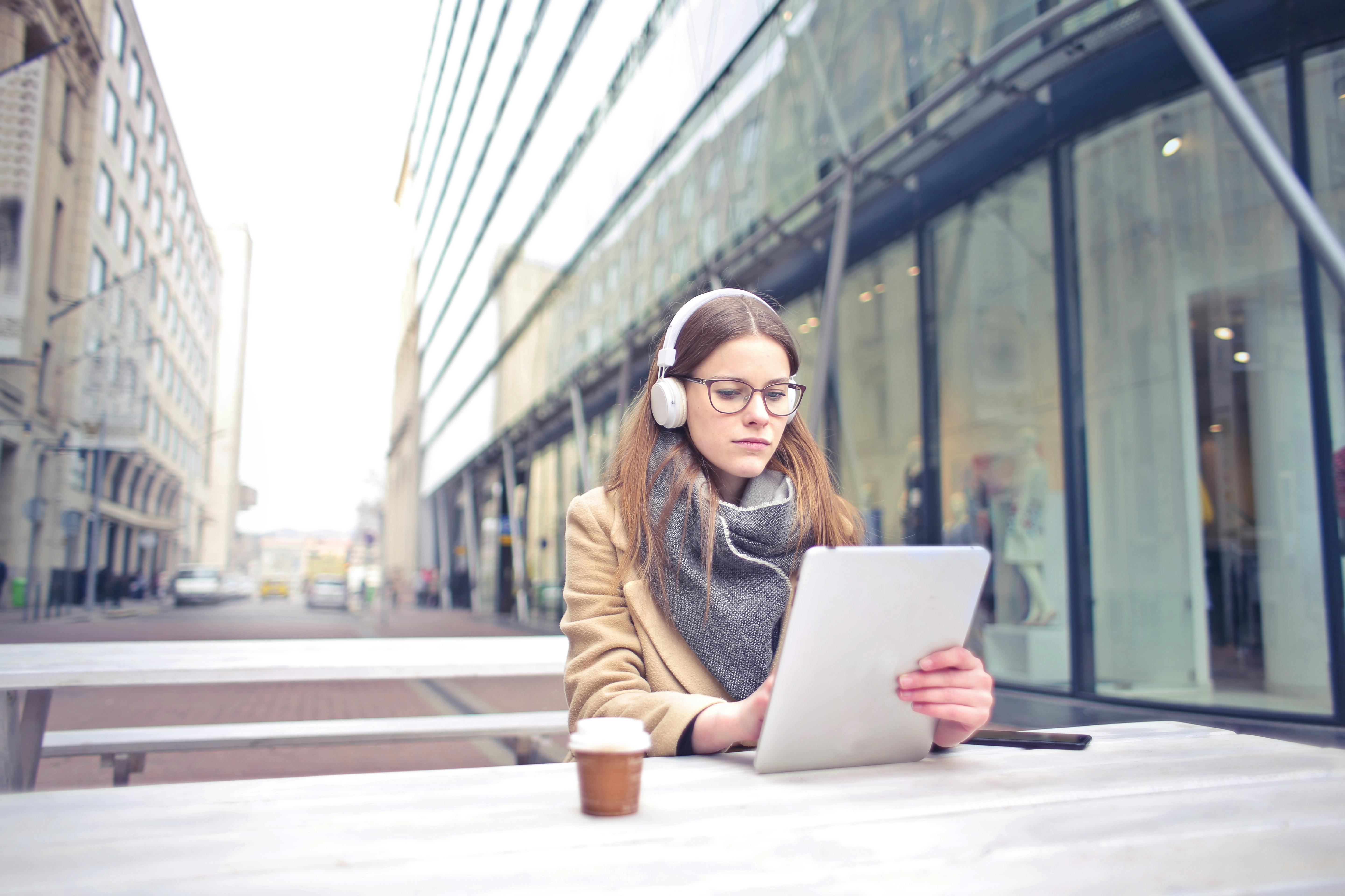 Woman In Brown Coat Using A Gadget · Free Stock Photo