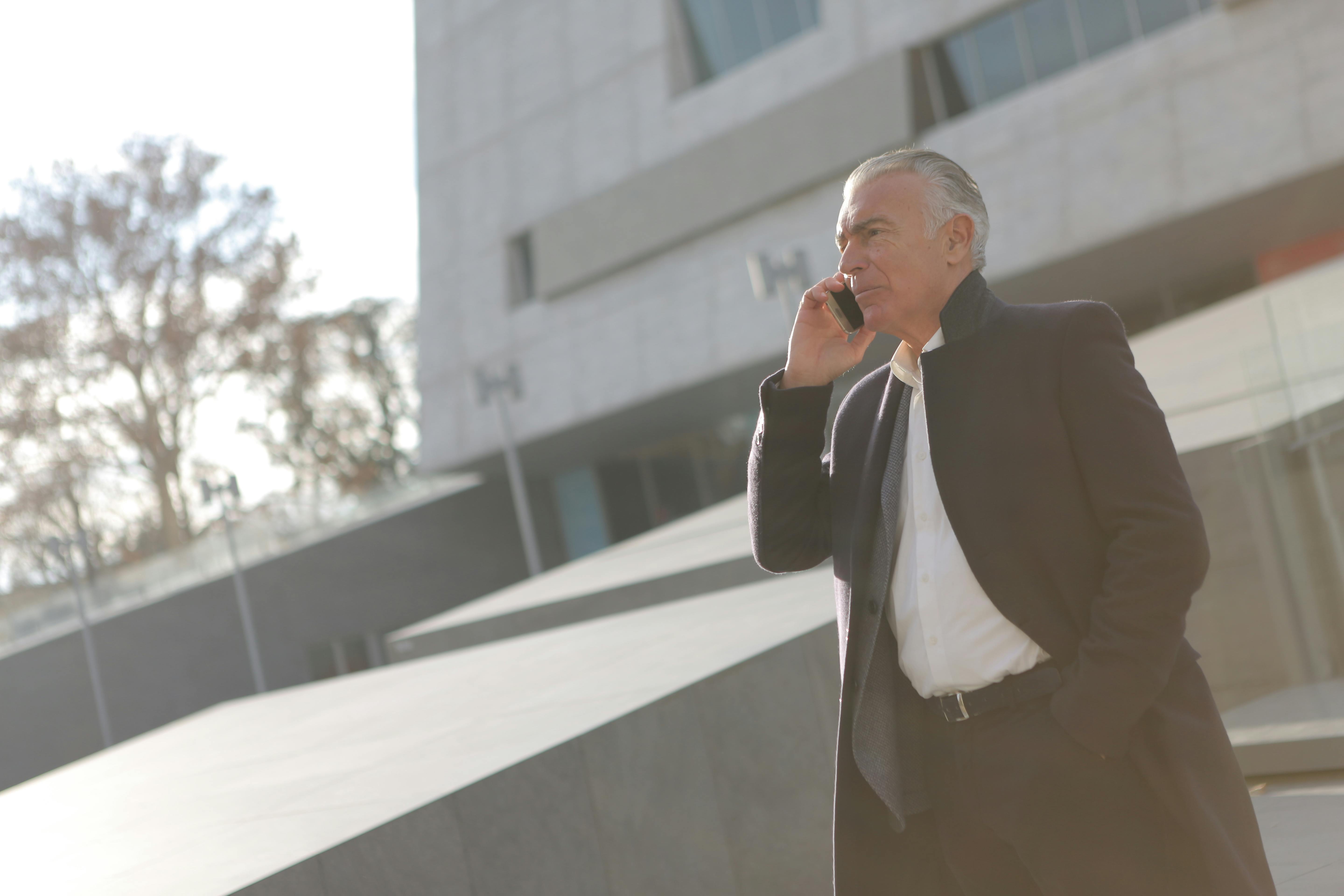 Man in Black Suit Jacket Talking on Phone · Free Stock Photo