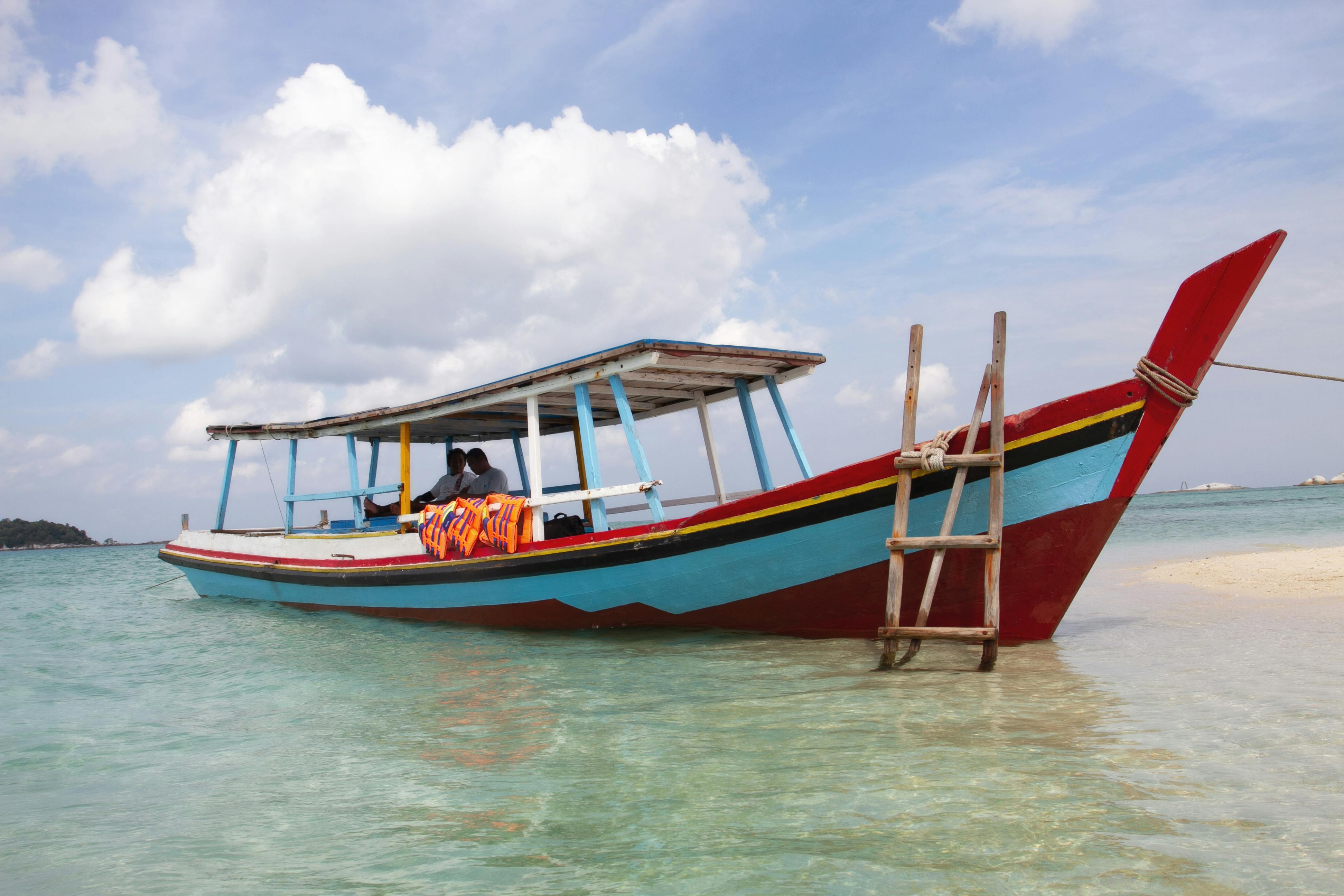 Red and Blue Boat on Sea Under White Clouds and Blue Sky · Free Stock Photo
