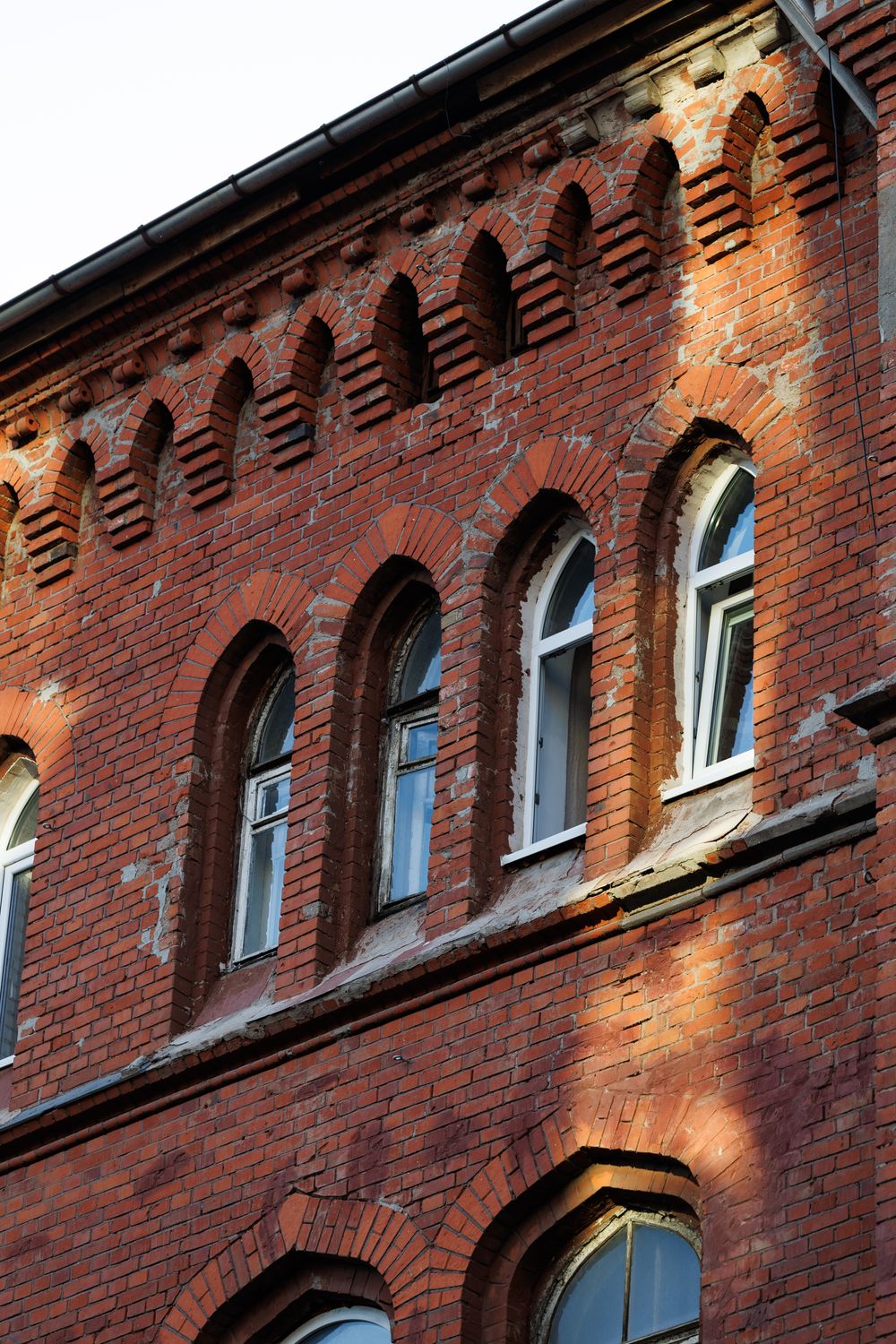 Facciata Di Un Edificio Storico In Mattoni Con Finestre Ad Arco ...