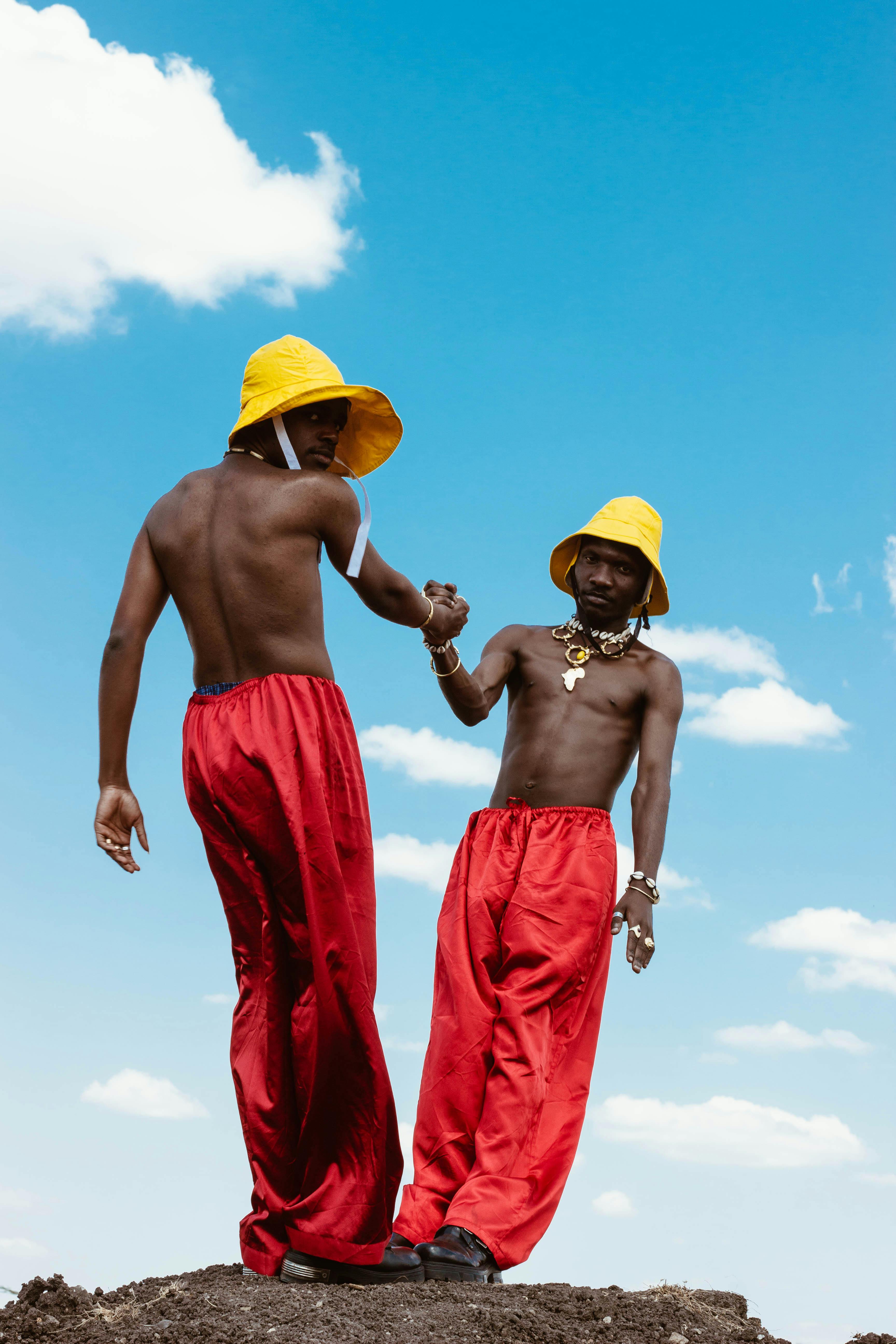Photo of Two Men Supporting Each Other Under Blue Sky · Free Stock Photo