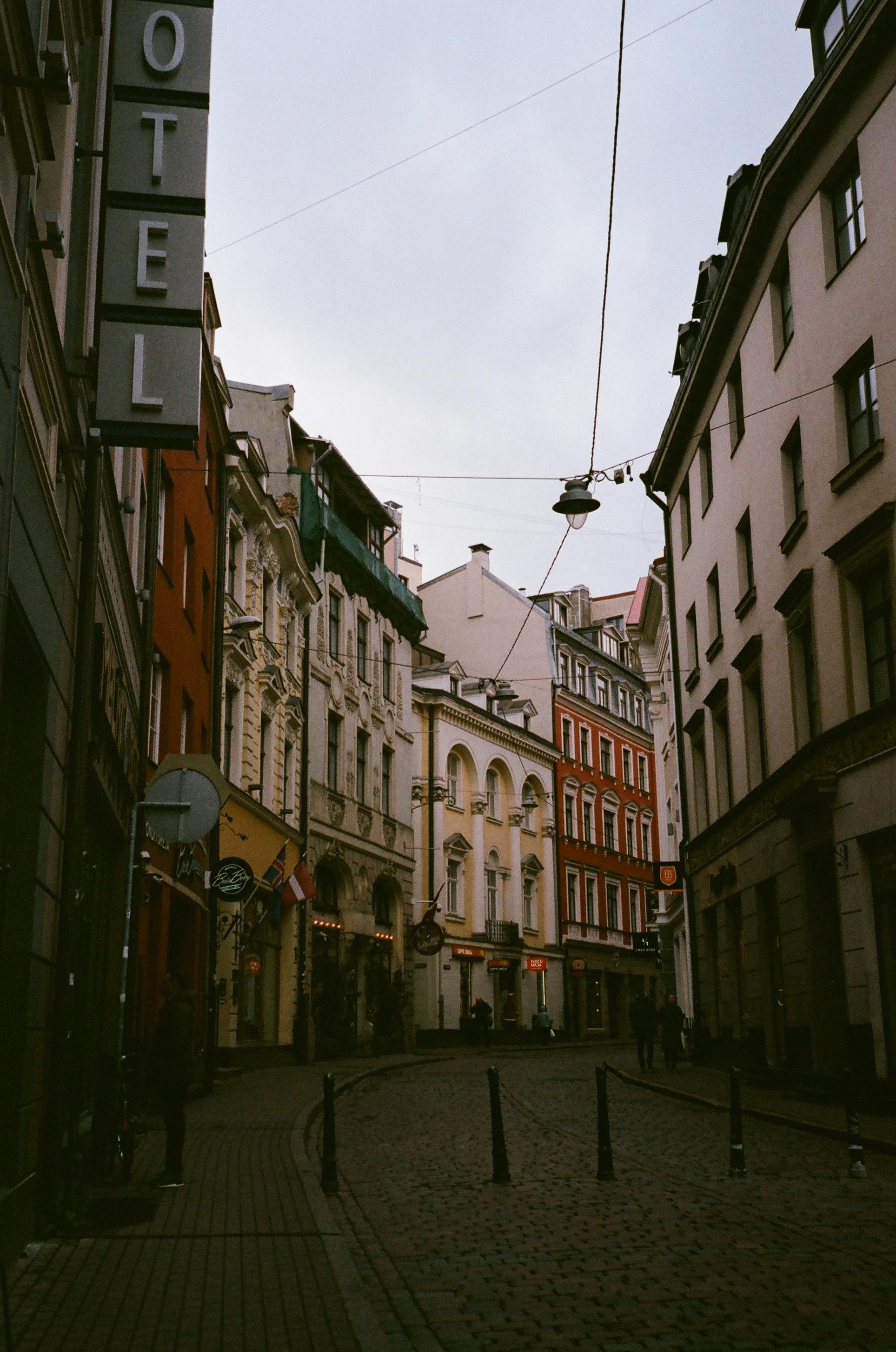 Old dark city street with house facades under serene sky · Free Stock Photo