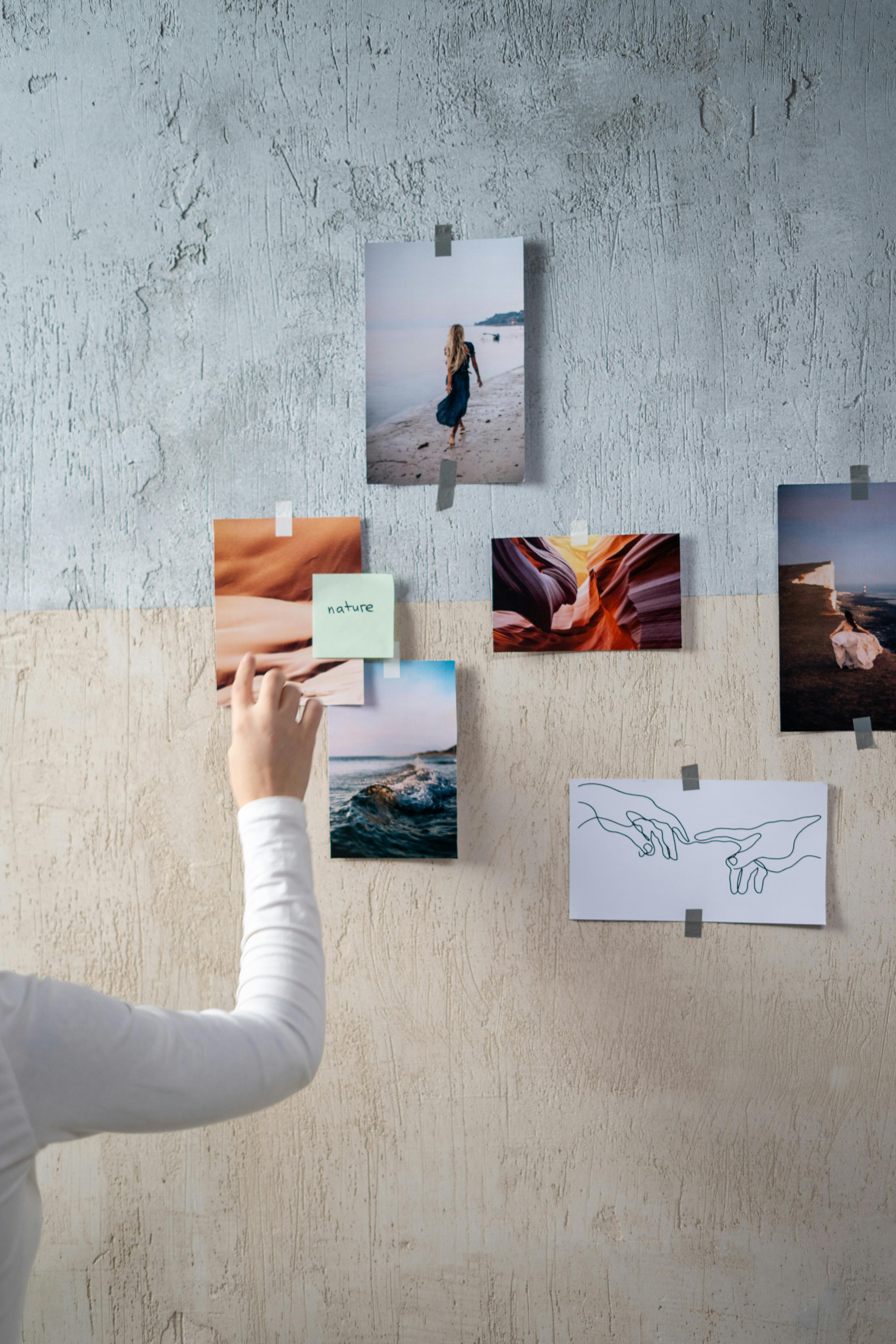 Person sticking a Picture on a Wall · Free Stock Photo