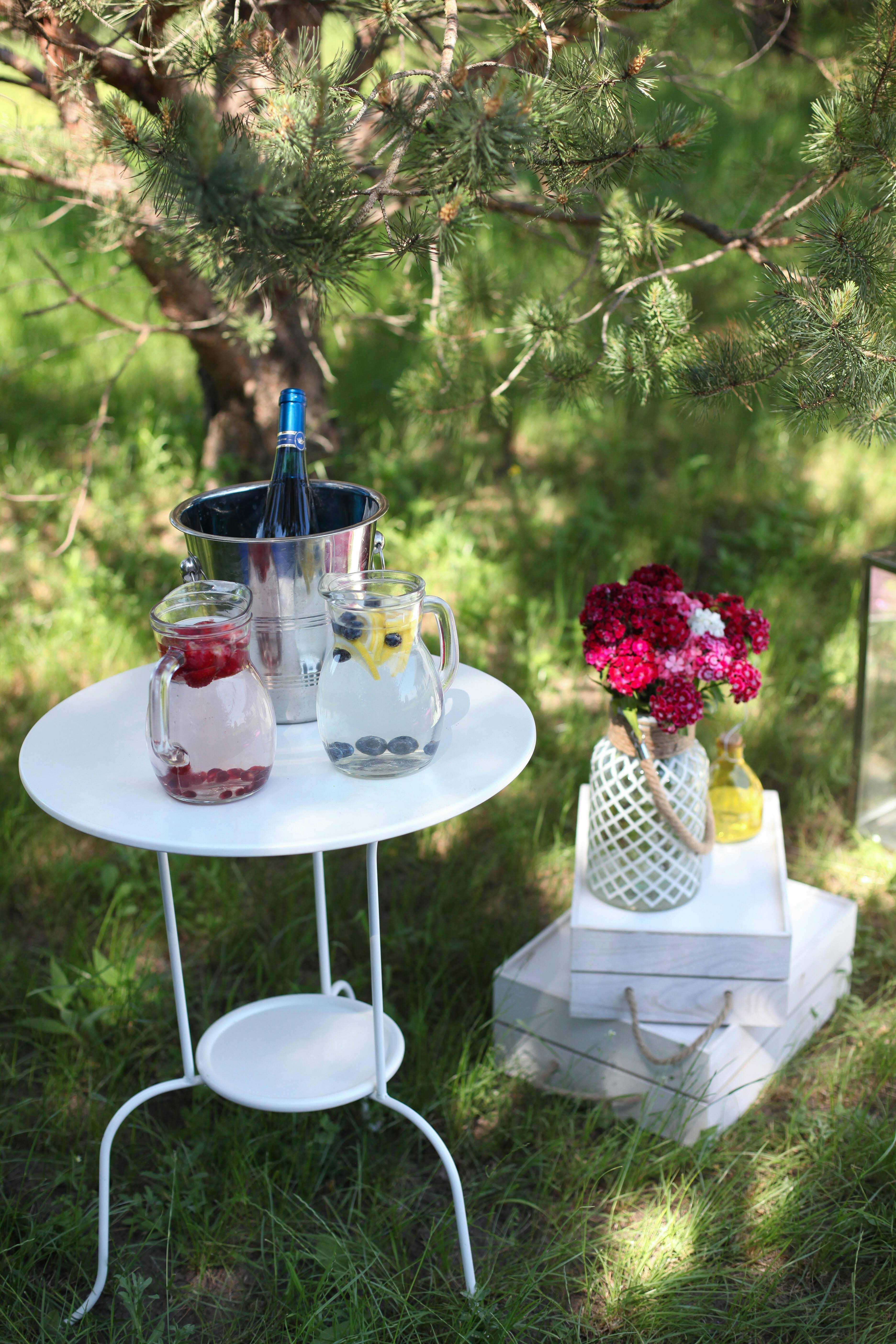 Garden table with refreshing drinks and flowers · Free Stock Photo