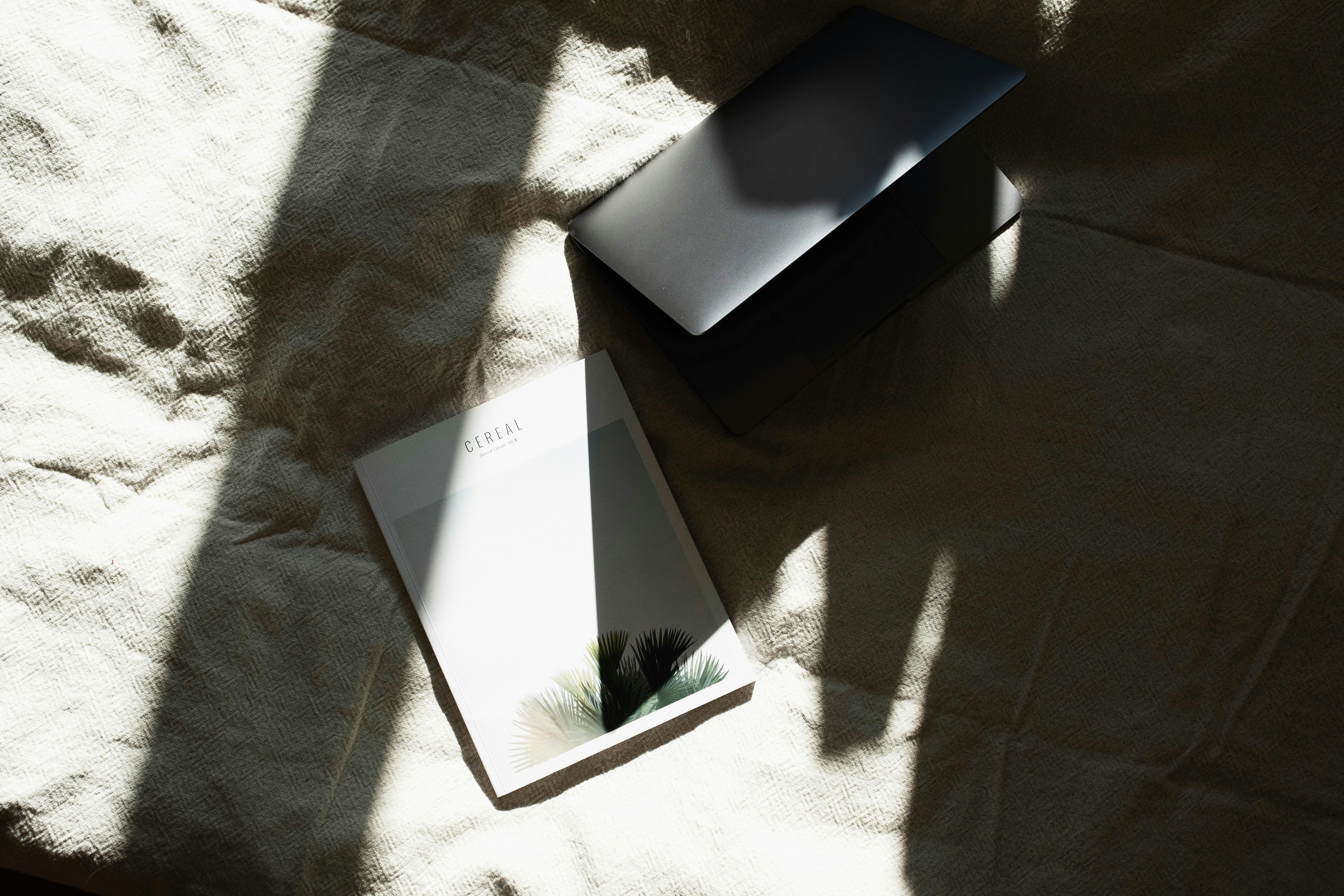 Laptop and book placed on blanket on bed in light bedroom · Free Stock ...