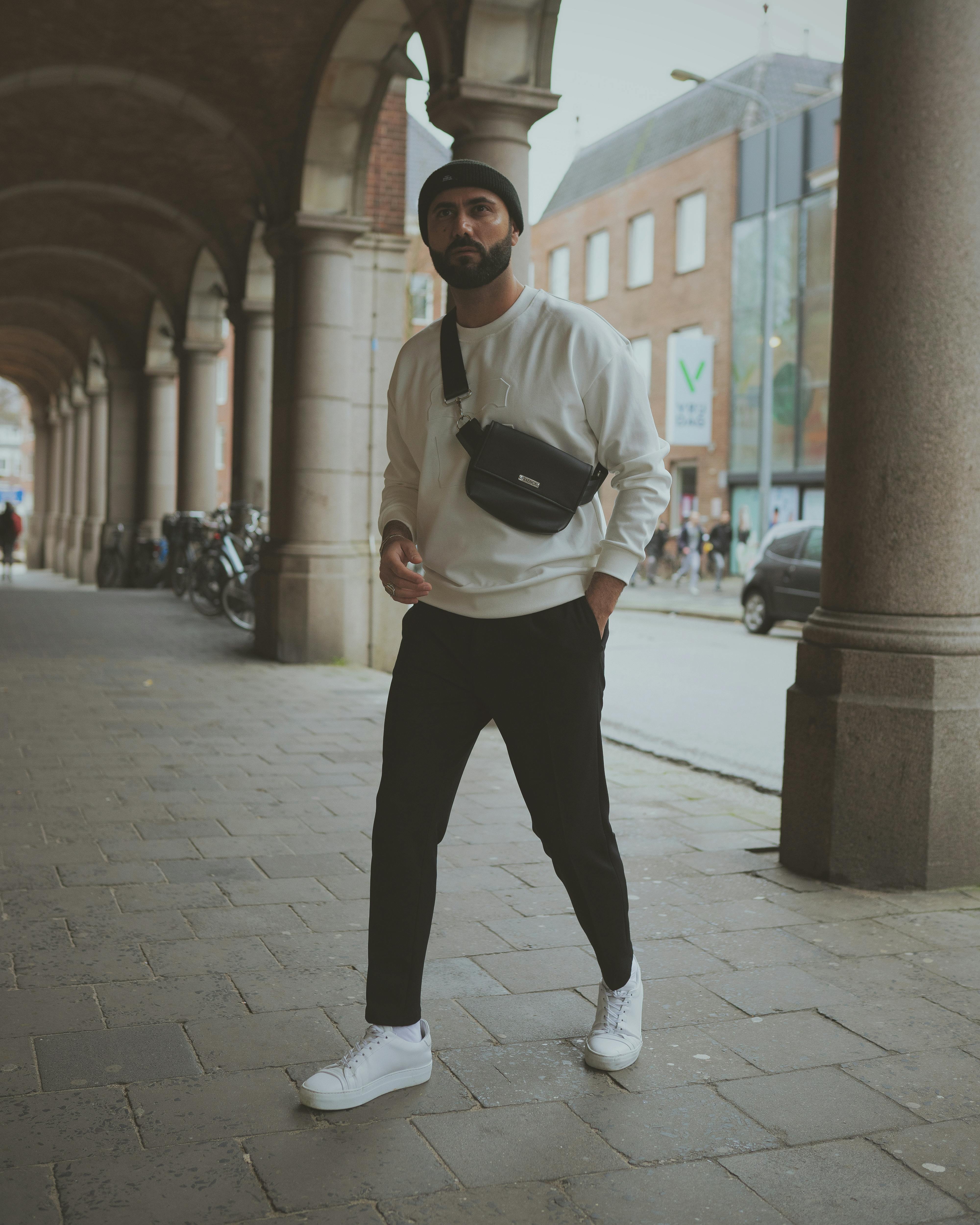 Ethnic man walking along arched passage on street · Free Stock Photo