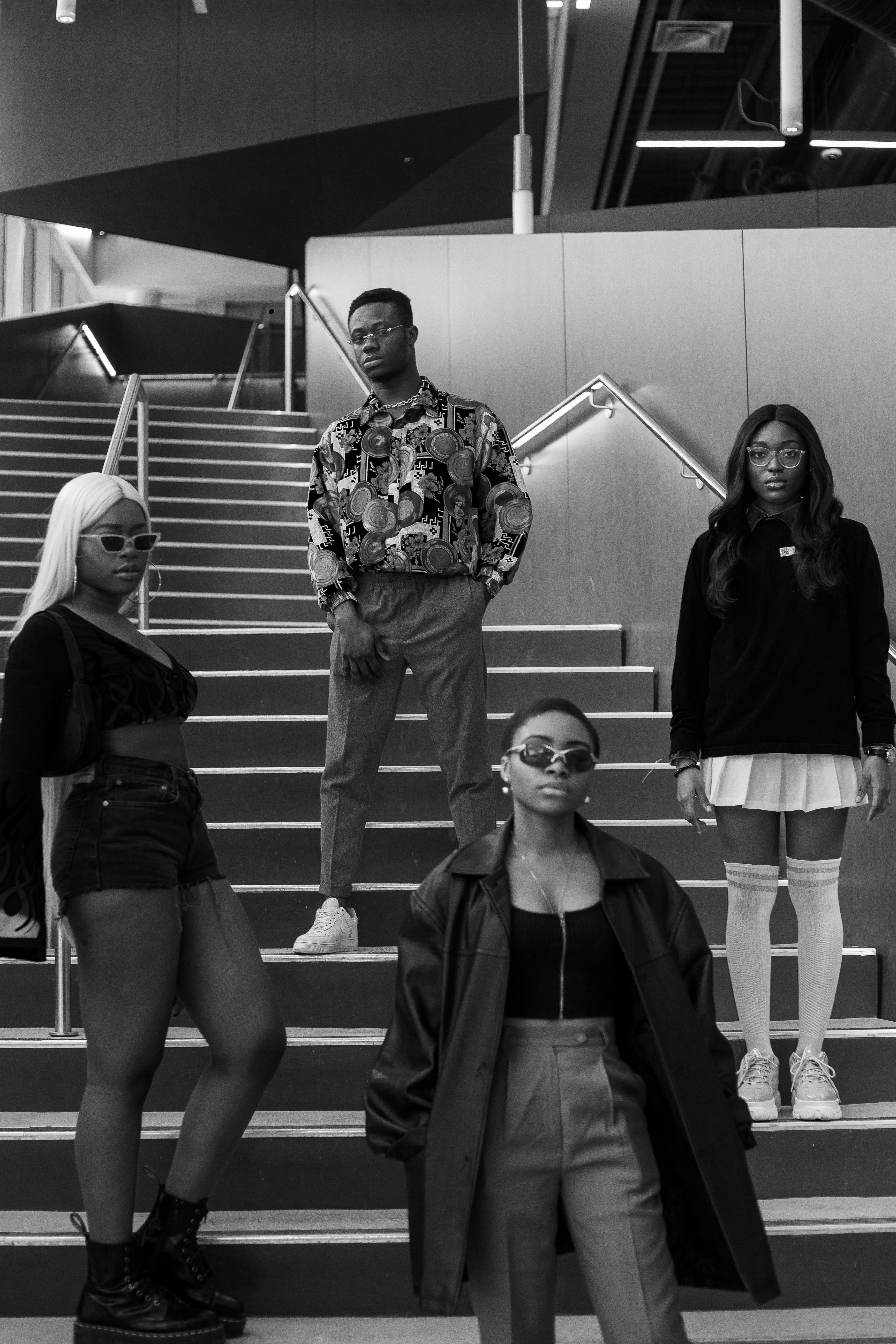 Fashionable young black friends standing on stairs in contemporary ...