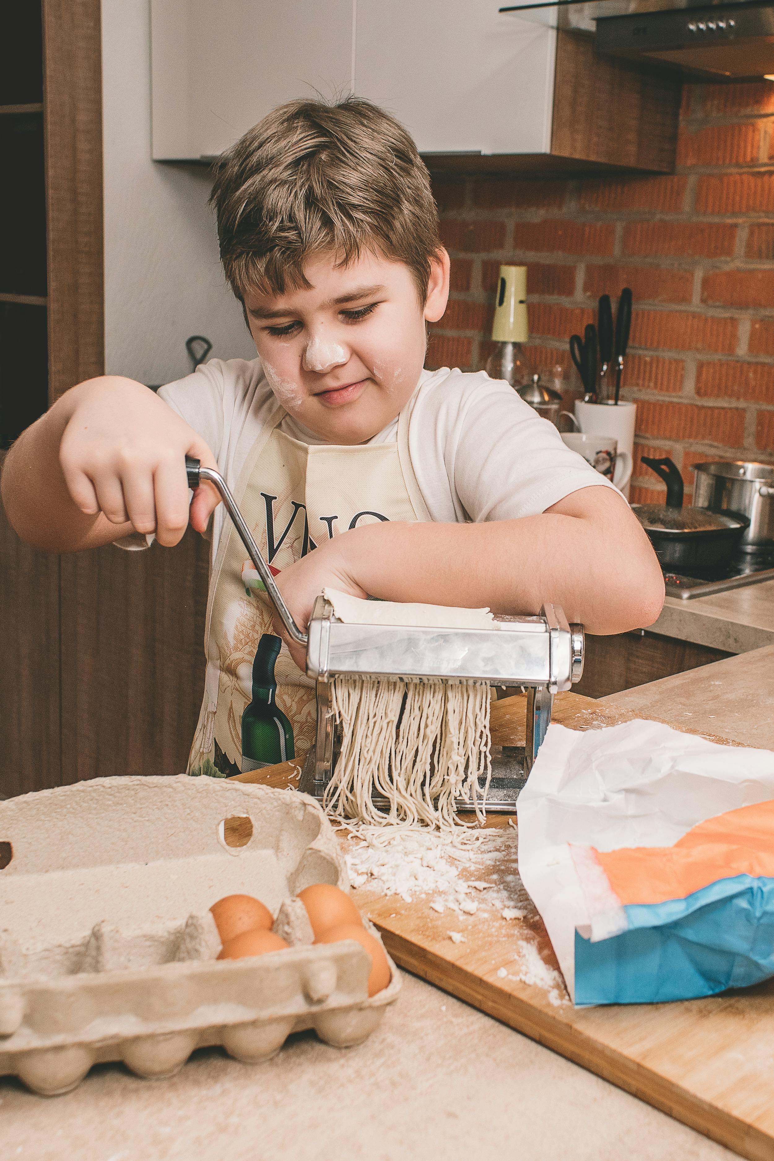 A Boy Using a Pasta Maker · Free Stock Photo