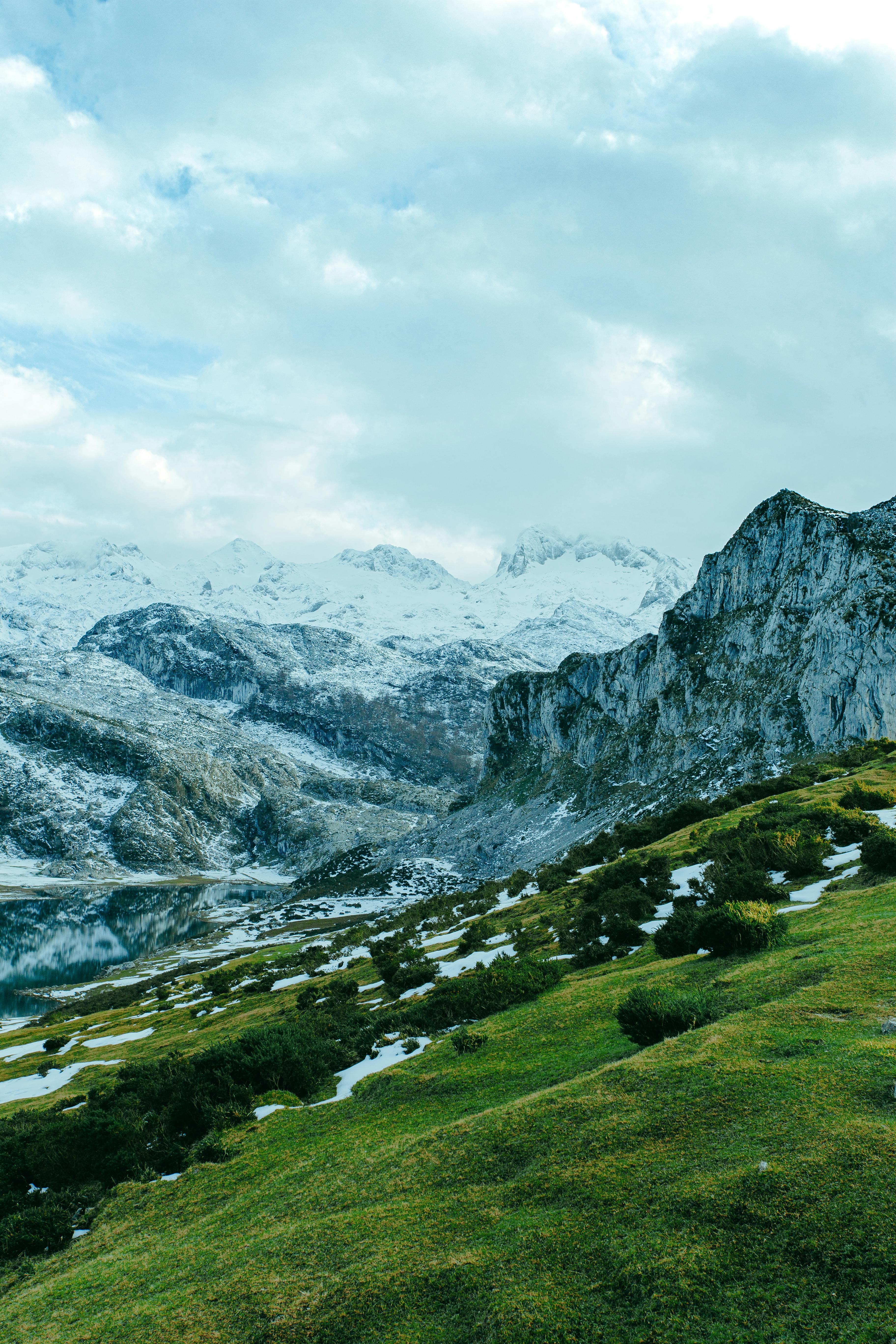 Green Grass Field Near Snow Covered Mountain · Free Stock Photo
