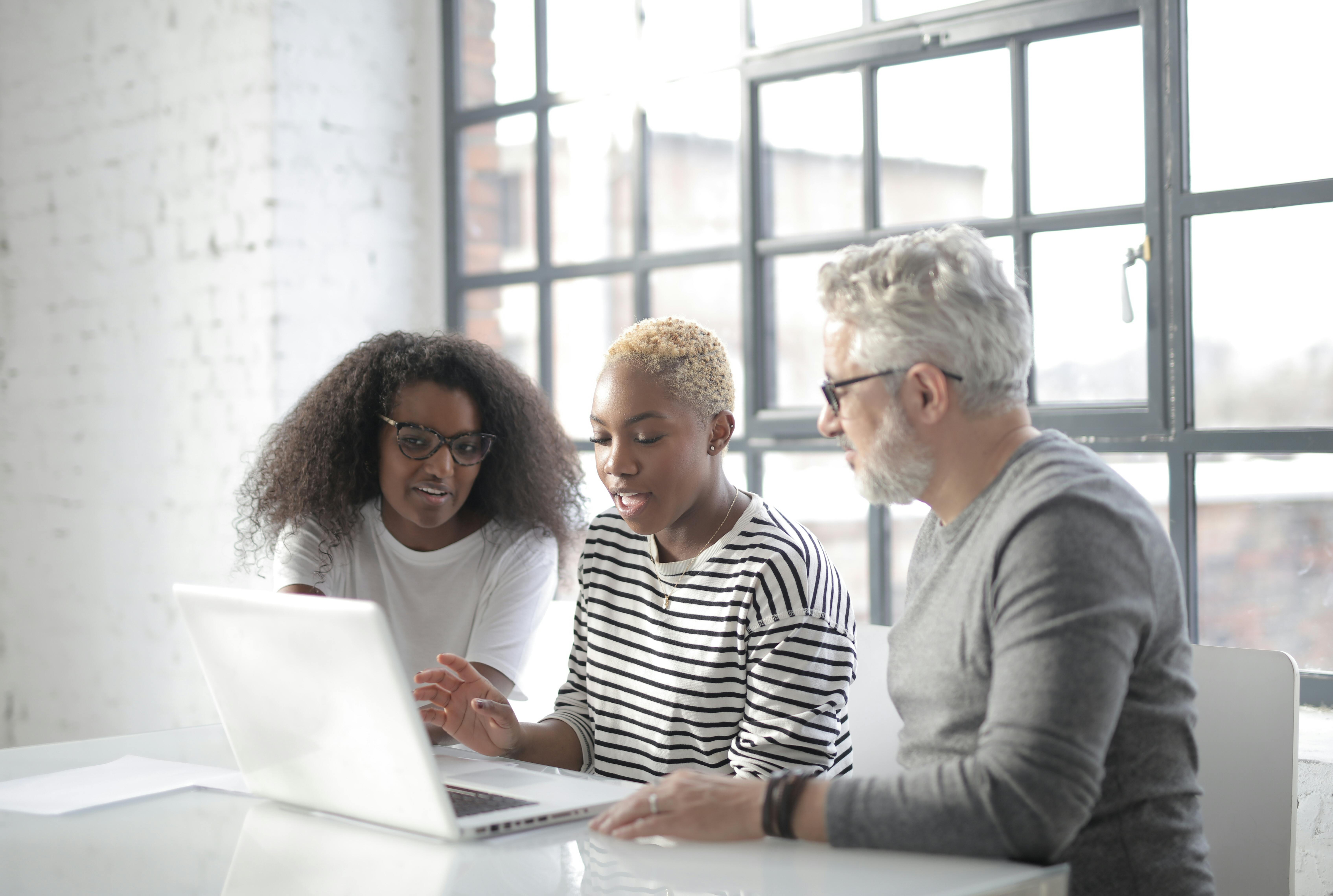 Concentrated multiracial coworkers working on laptop in modern ...