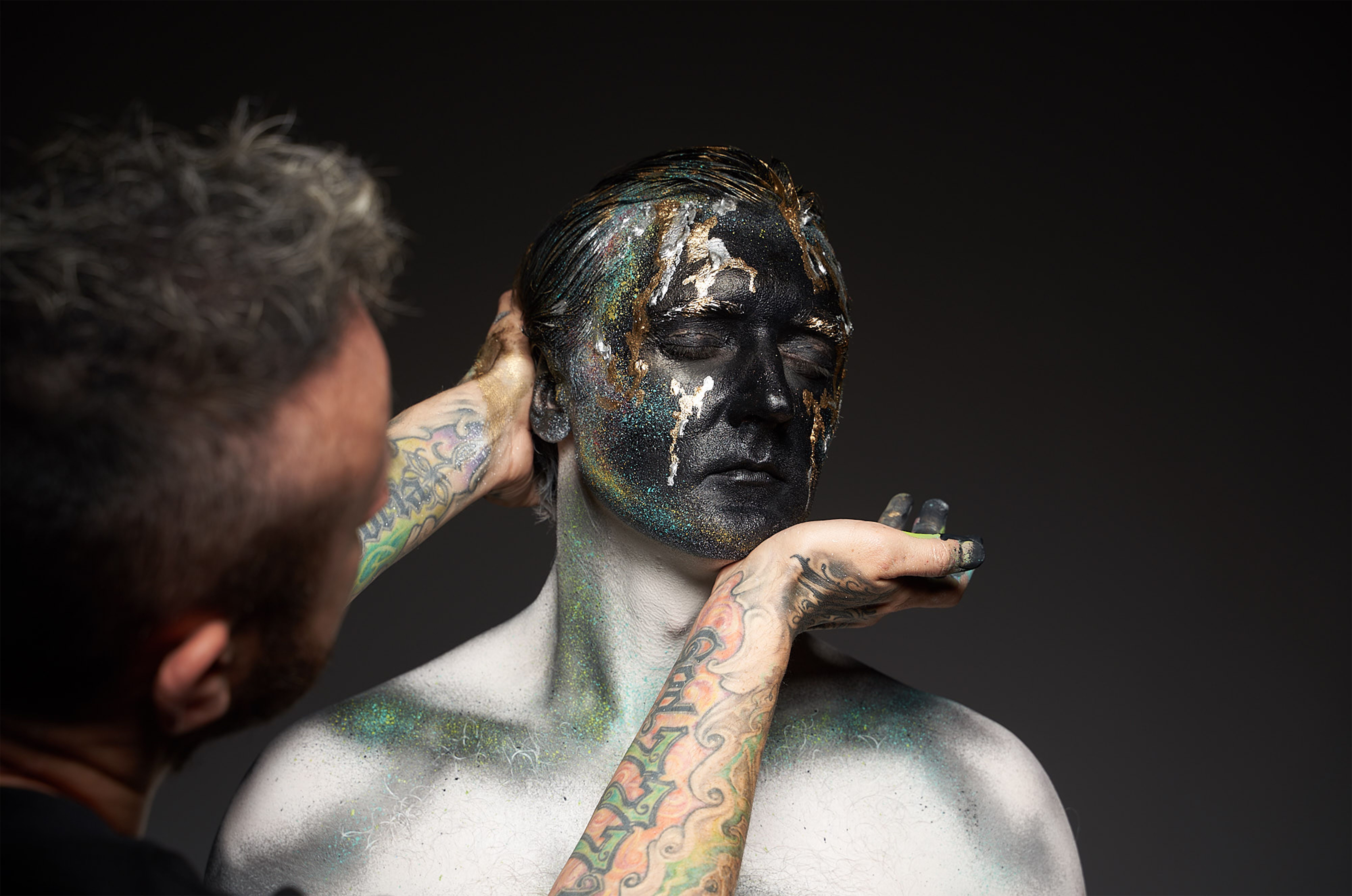 Professional male model and makeup artist cooperating during photo ...