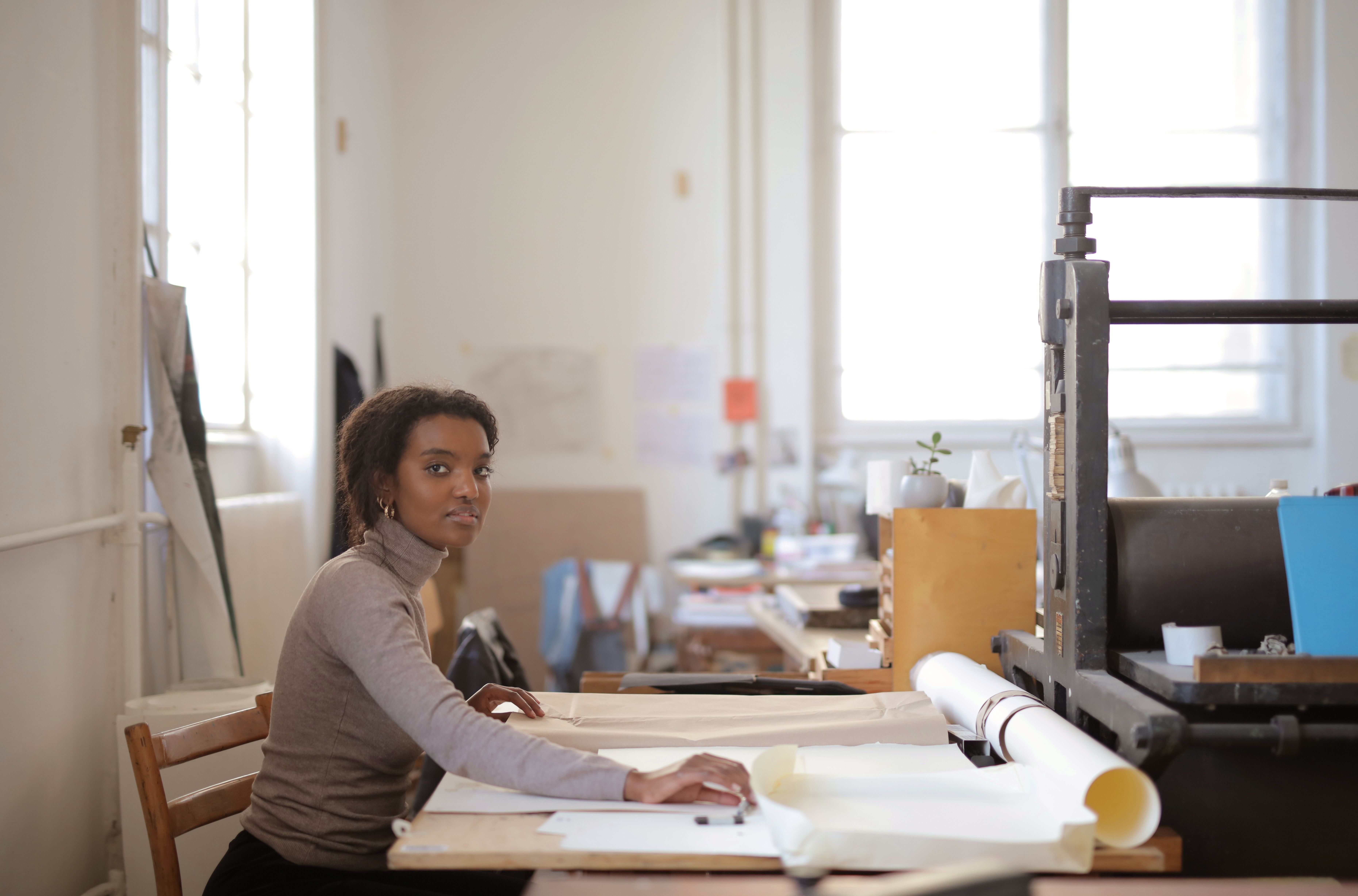 African American craftswoman sitting at table with papers · Free Stock ...