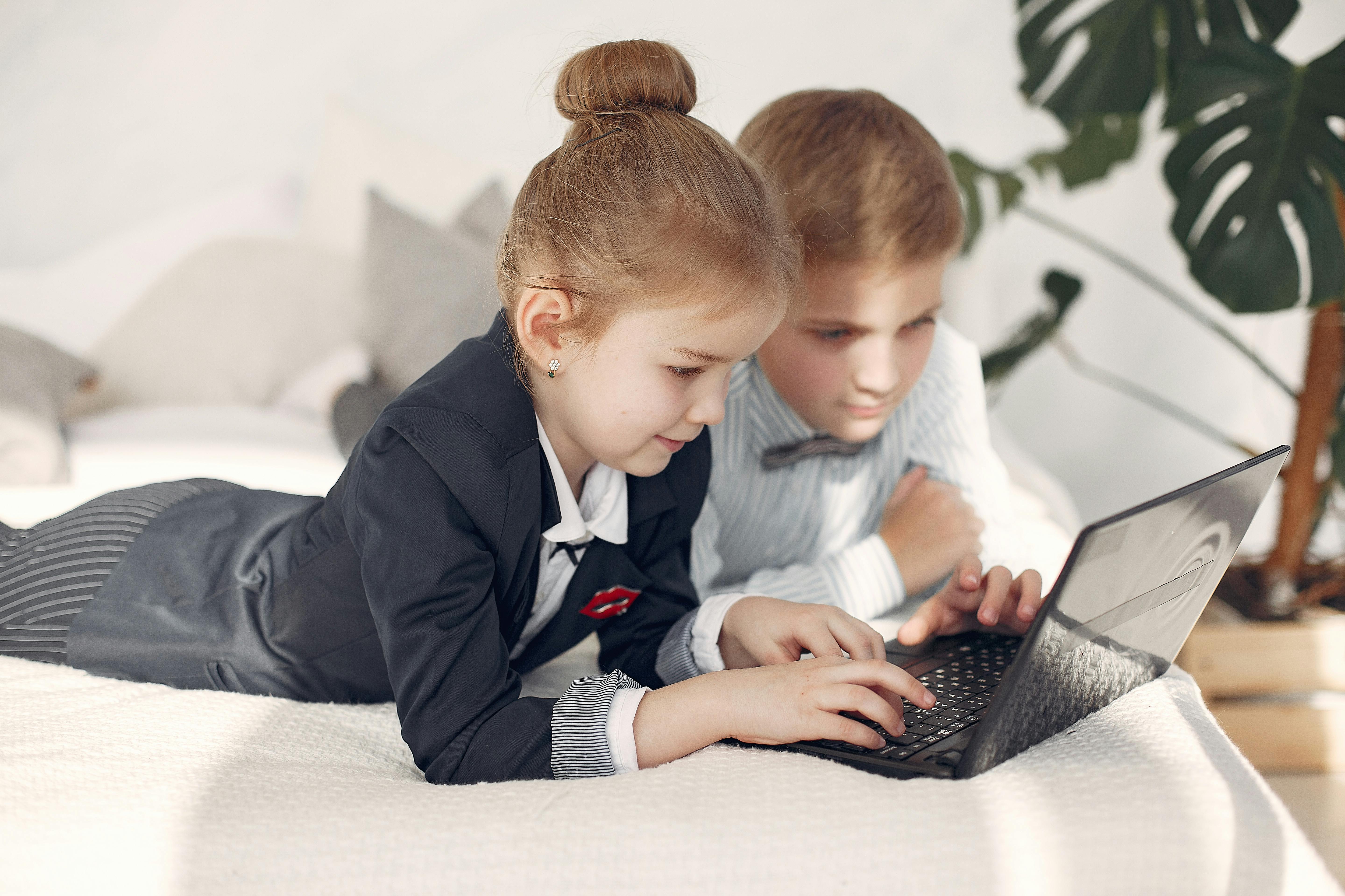 Smart little business children in formal outfits working with laptop ...