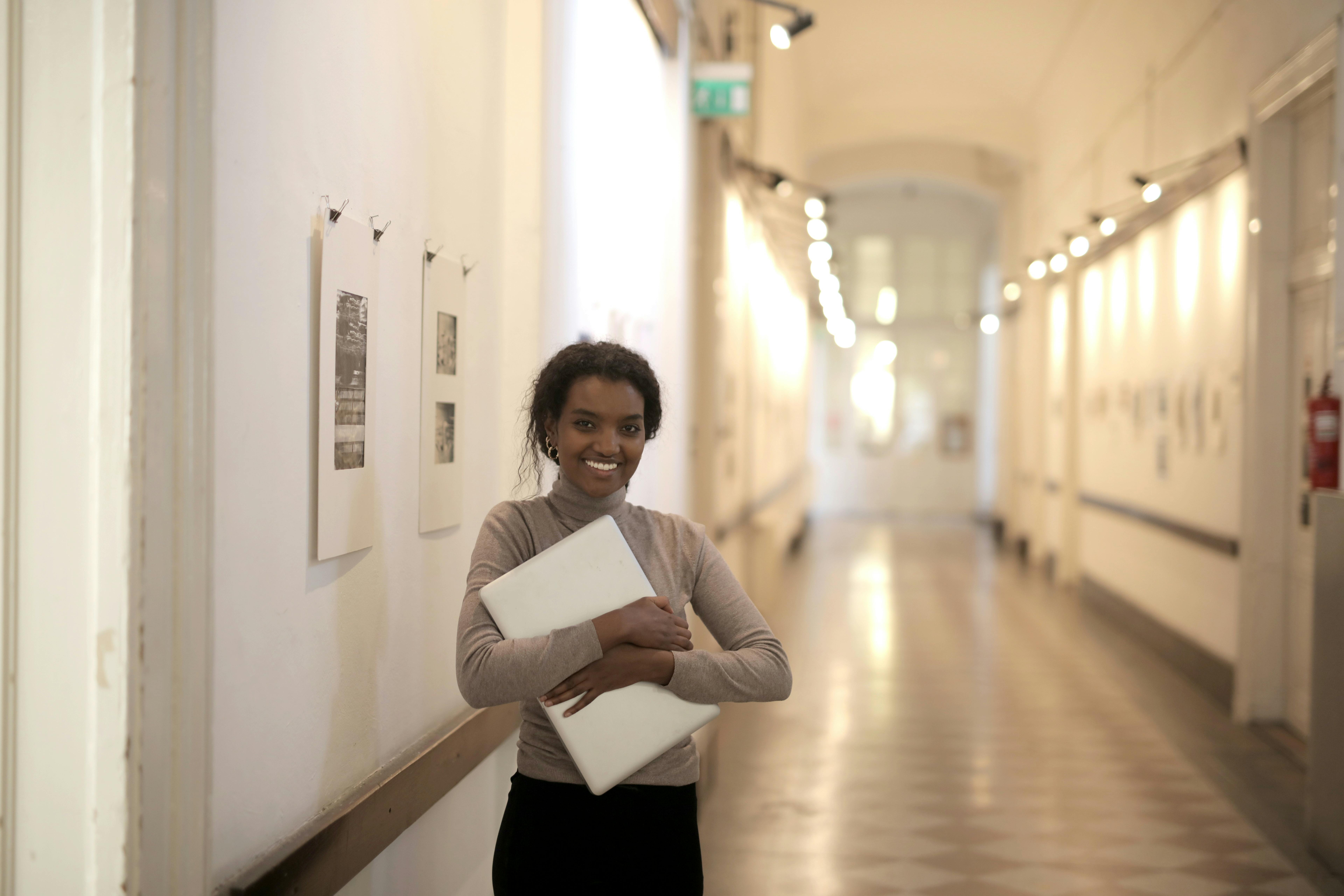 Young woman with clipboard in corridor · Free Stock Photo