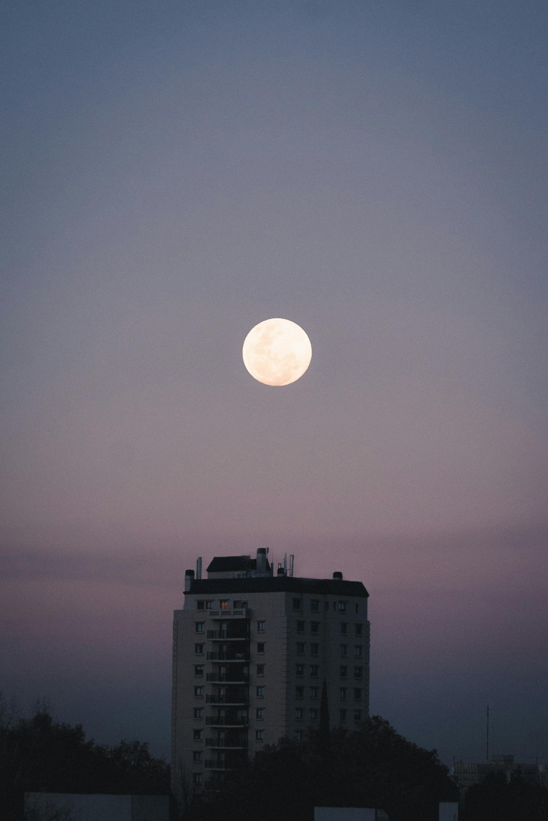 Full Moon Over White Concrete Building · Free Stock Photo