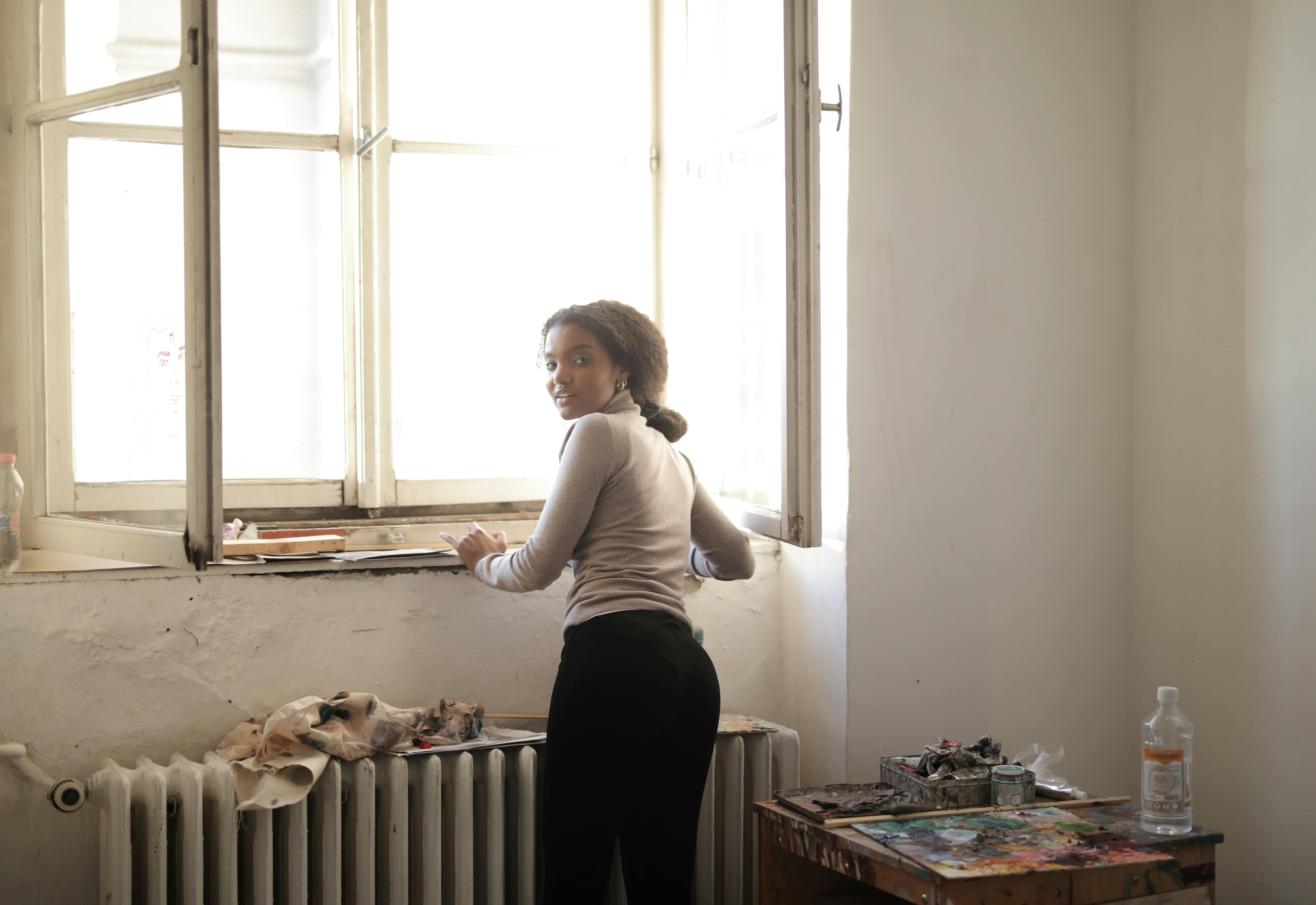 Young woman standing near window · Free Stock Photo