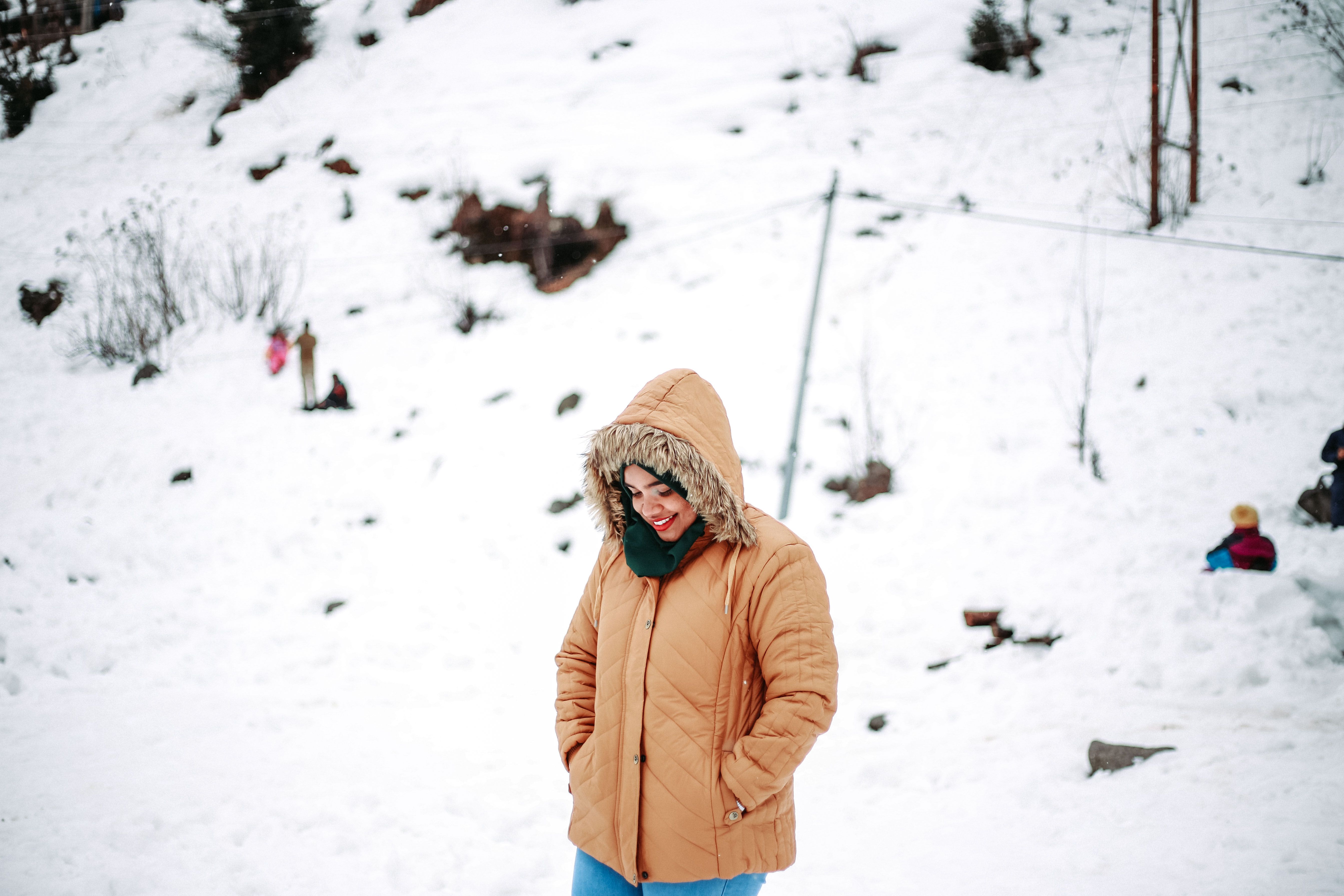 Woman in Brown Jacket Standing on Snow Covered Ground · Free Stock Photo