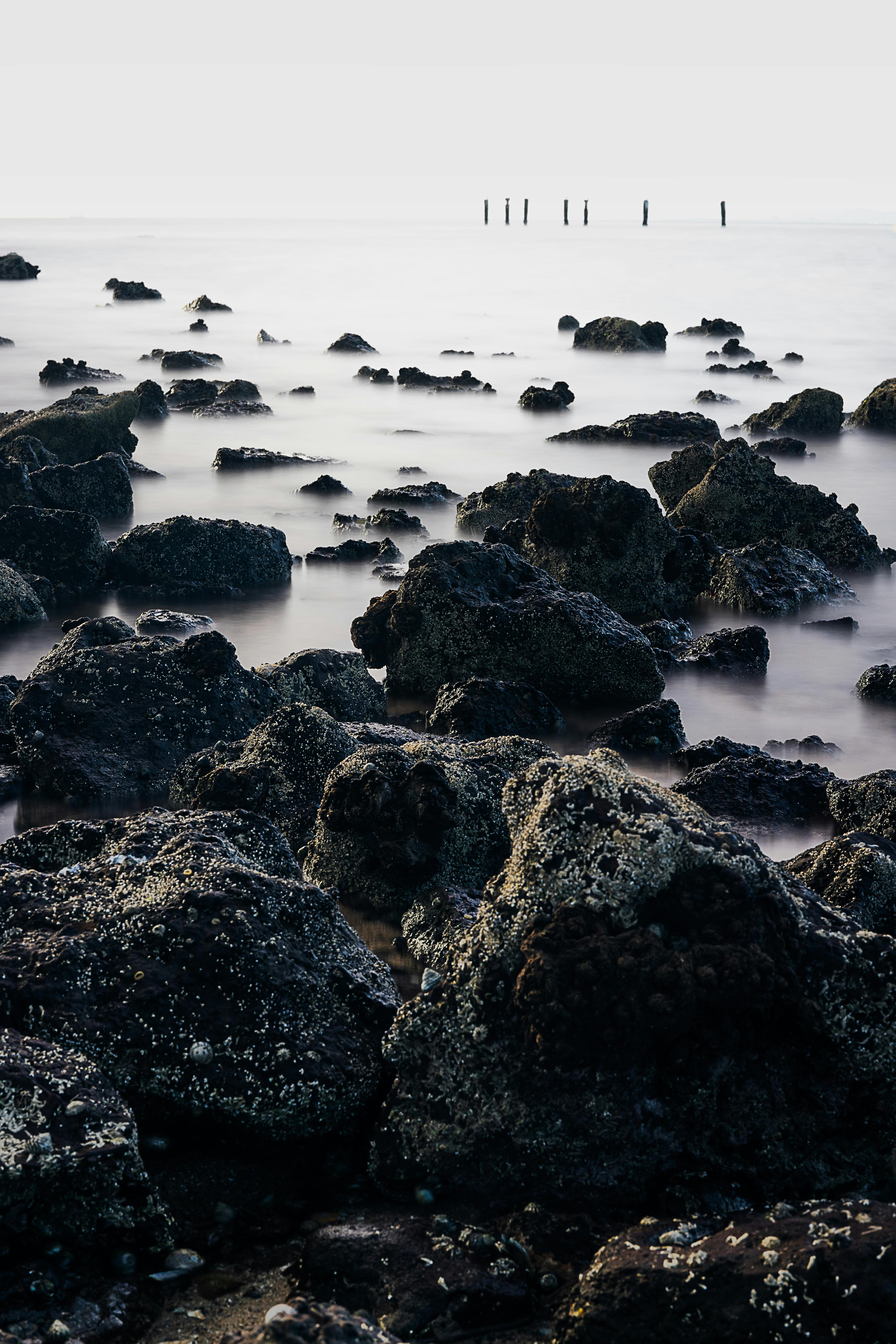 Black Rock Formations on Body of Water · Free Stock Photo