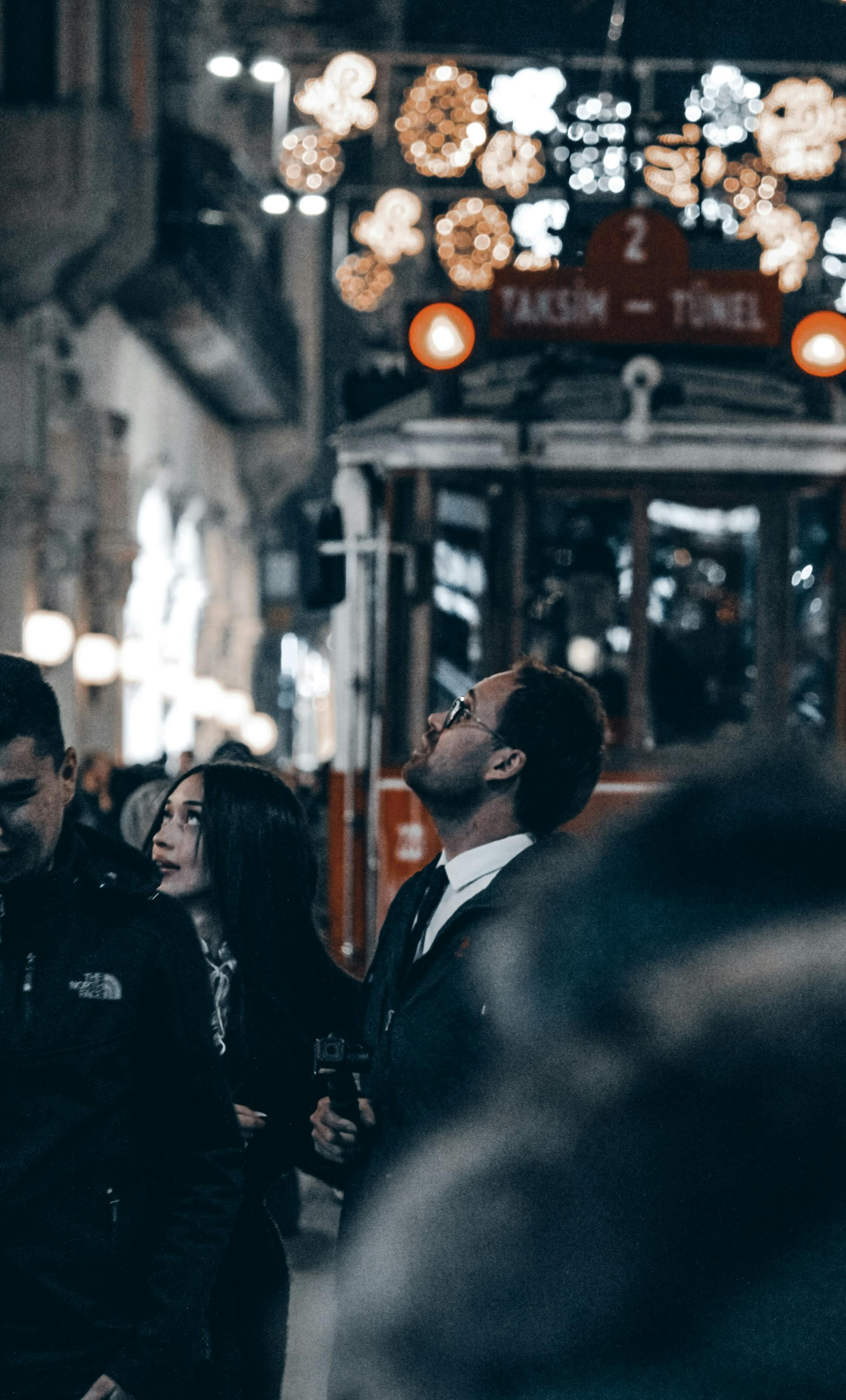 Couple standing on crowded street at night · Free Stock Photo