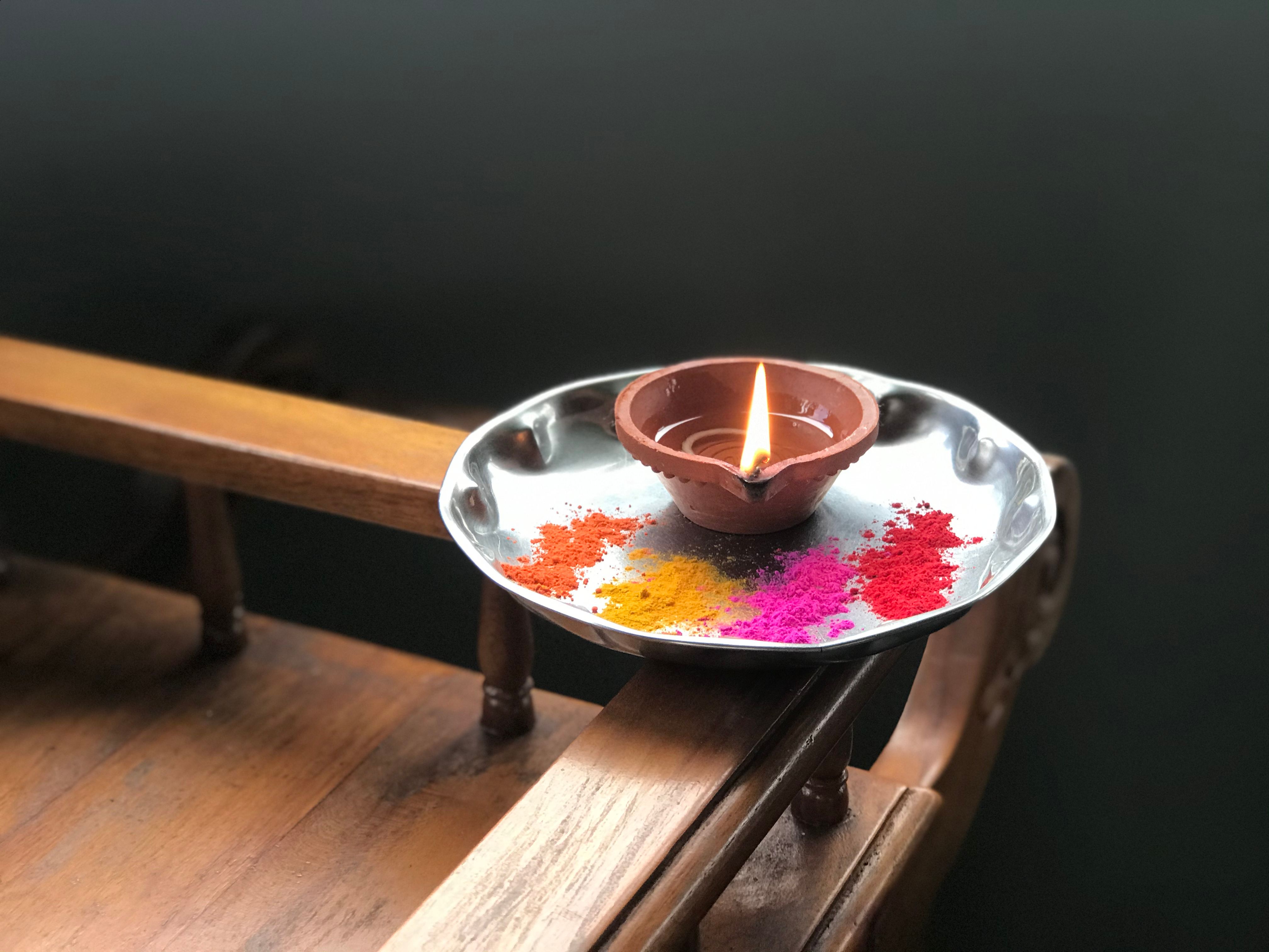 Candle and colorful powder on metallic plate · Free Stock Photo