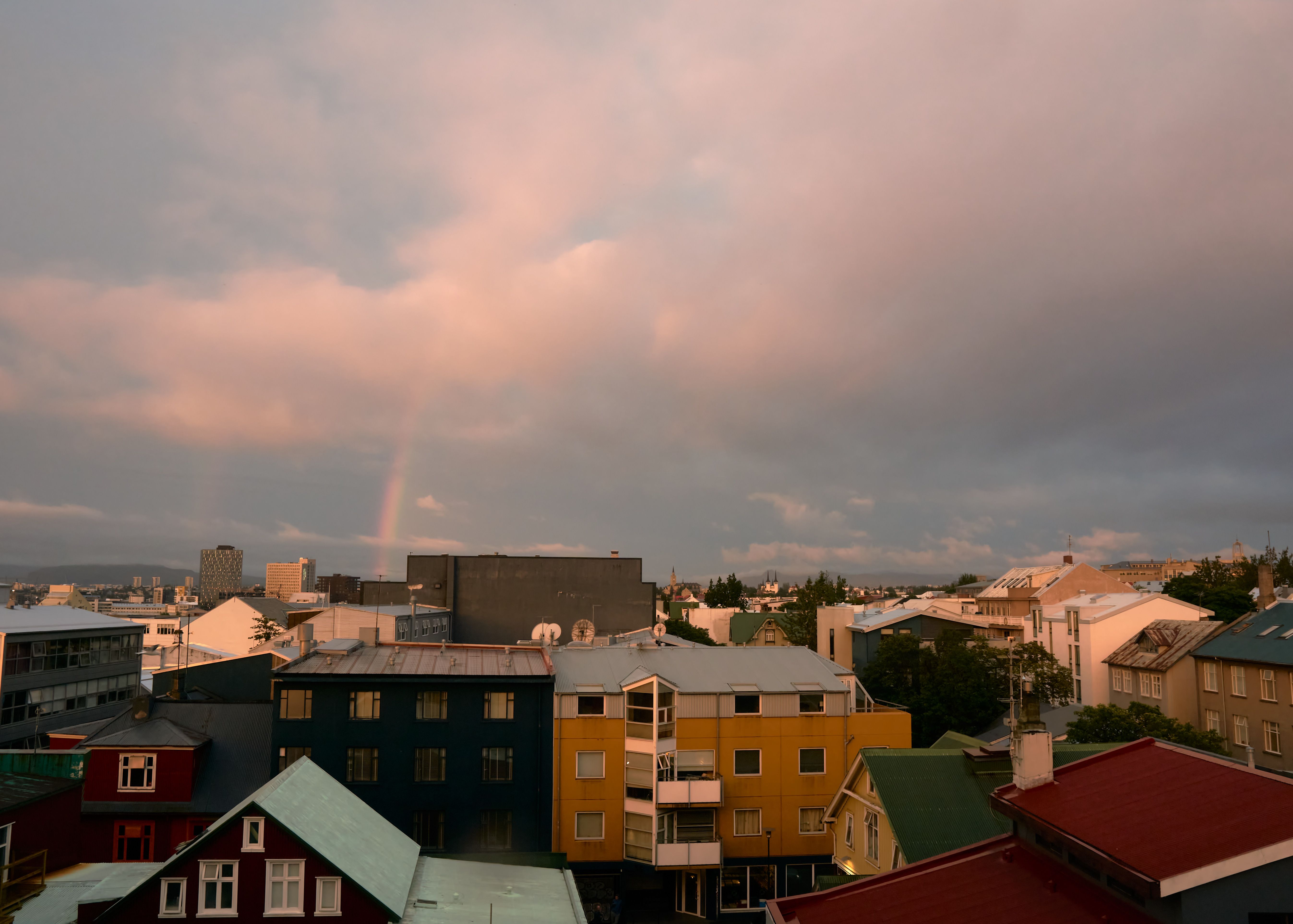 Small town under cloudy sky and rainbow · Free Stock Photo