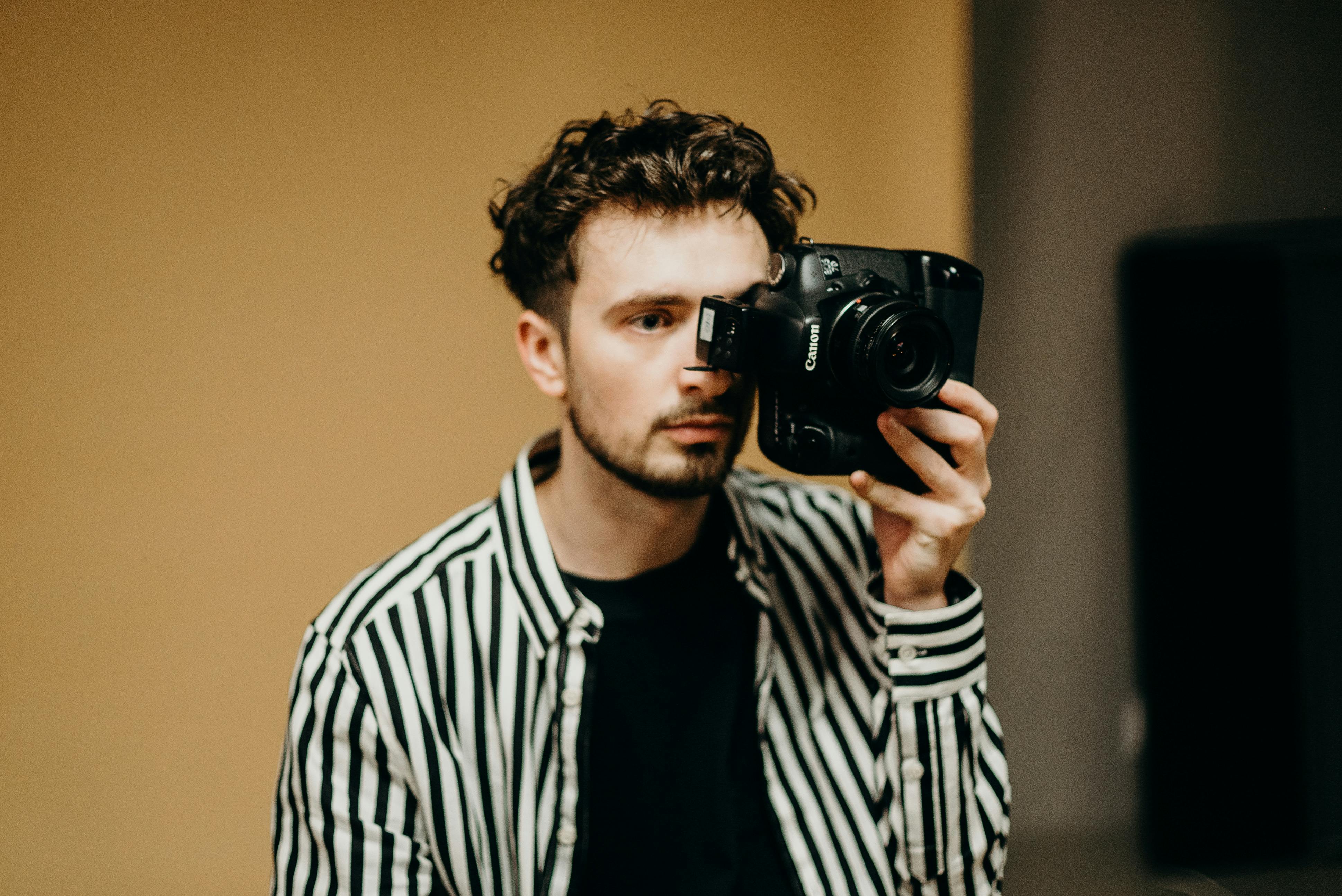 Selective Focus Photography of Man Sits While Holding Camera · Free ...